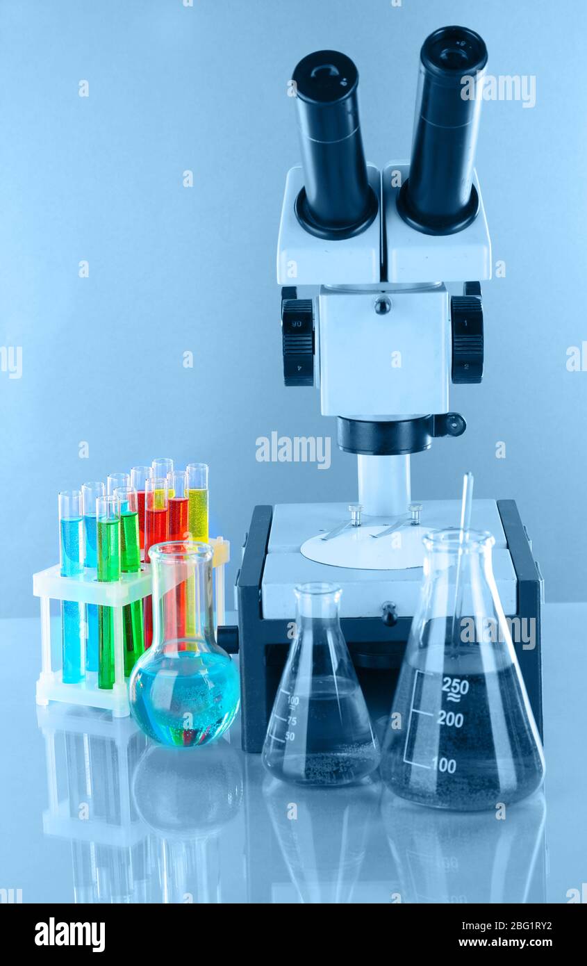 Test tubes with colorful liquids and microscope in blue light Stock ...