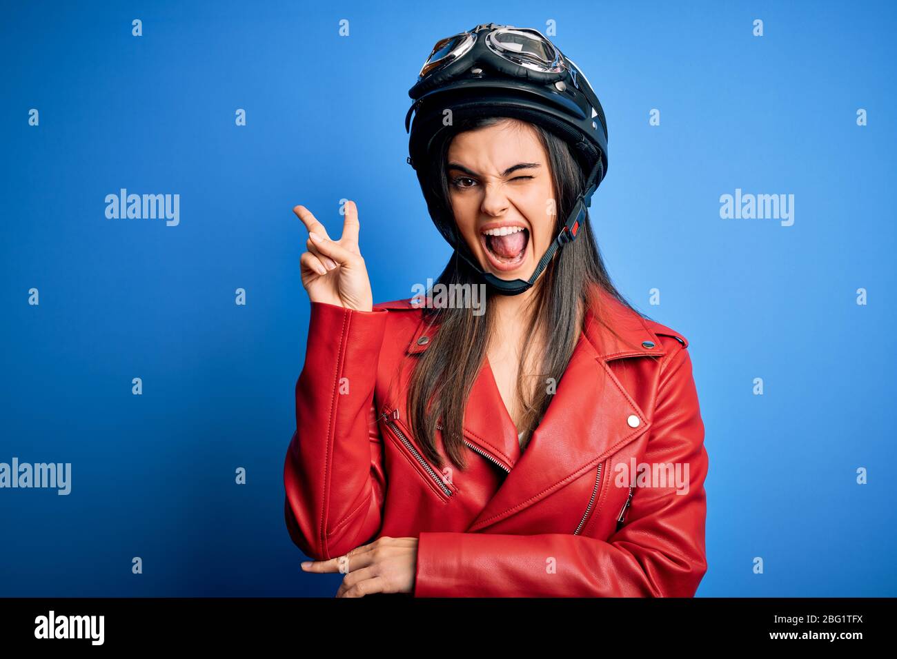 Young beautiful brunette motorcycliste woman wearing motorcycle helmet ...