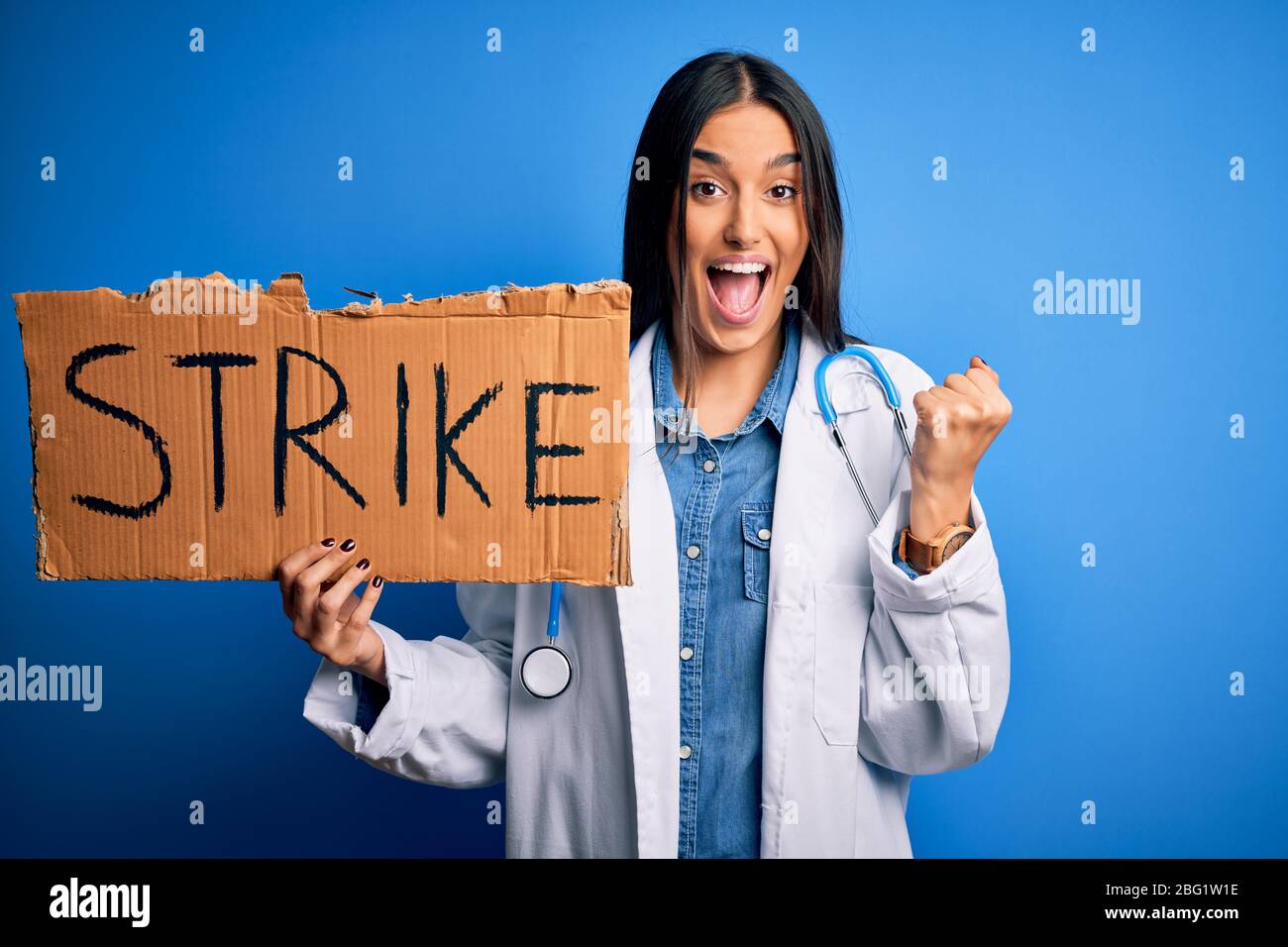 Young doctor woman wearing stethoscope holding cardboard banner ...