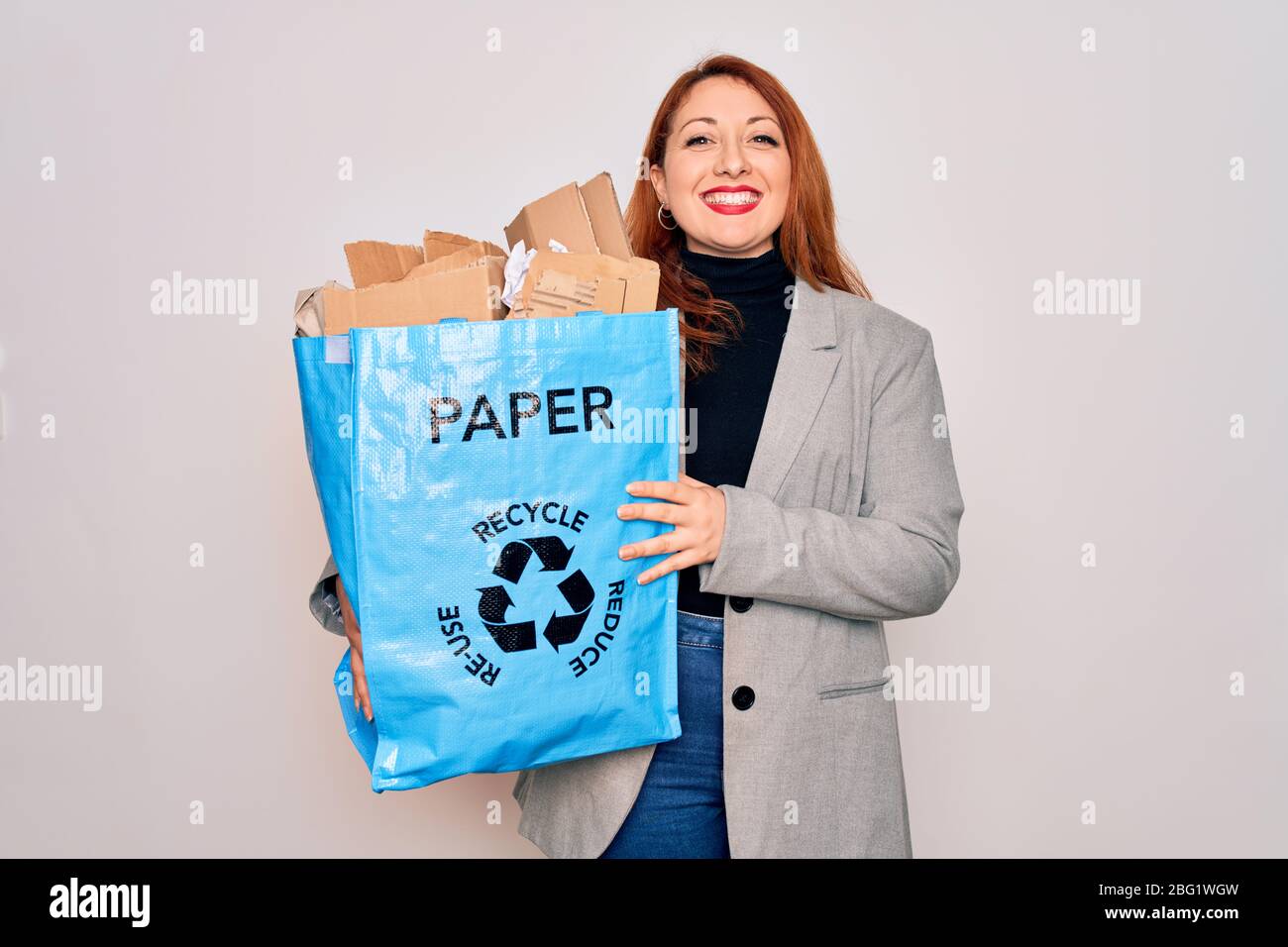 Young beautiful redhead woman recycling holding paper bag with ...