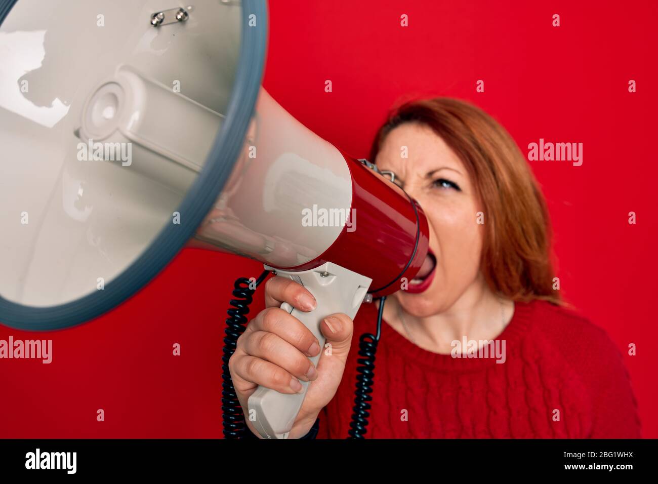Young beautiful redhead speaker woman screaming communicate using ...