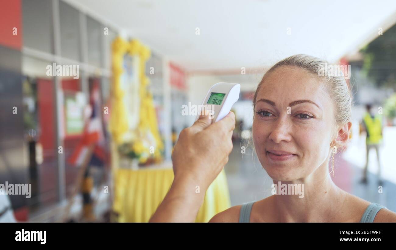 Temperature check at a supermarket of woman, grocery store with thermal ...