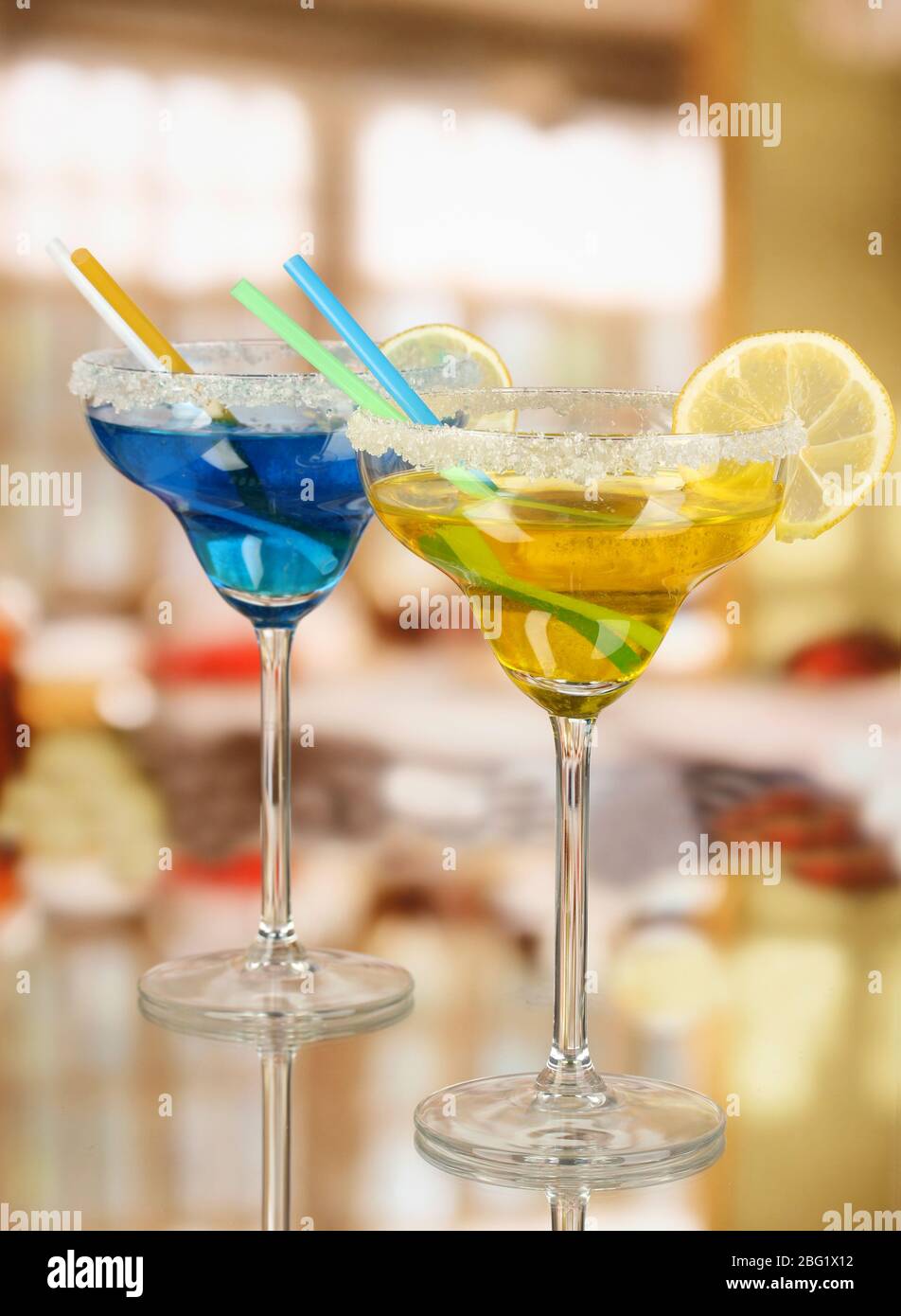 Yellow and blue cocktails in glasses on room background Stock Photo - Alamy