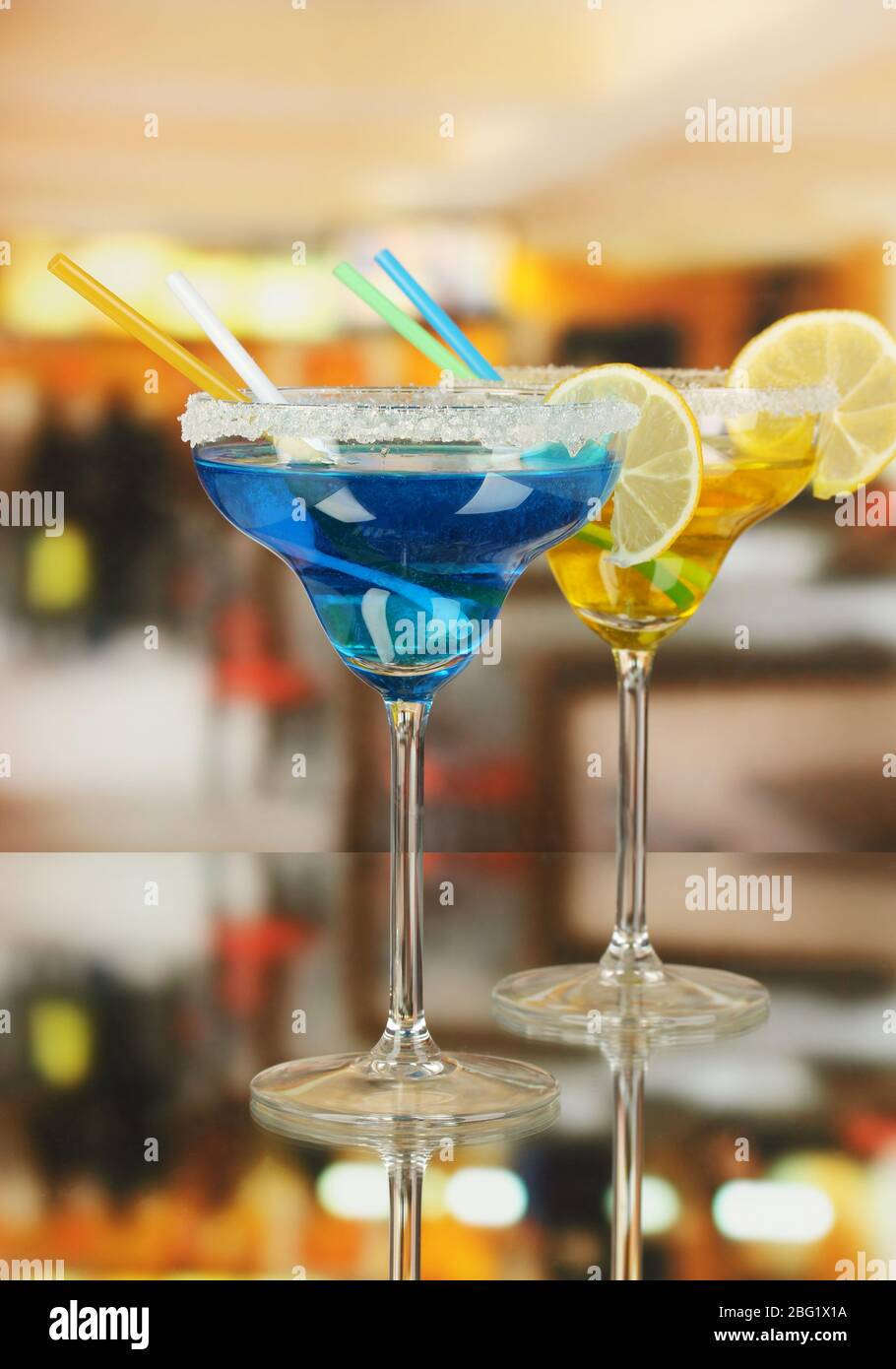 Yellow and blue cocktails in glasses on room background Stock Photo - Alamy