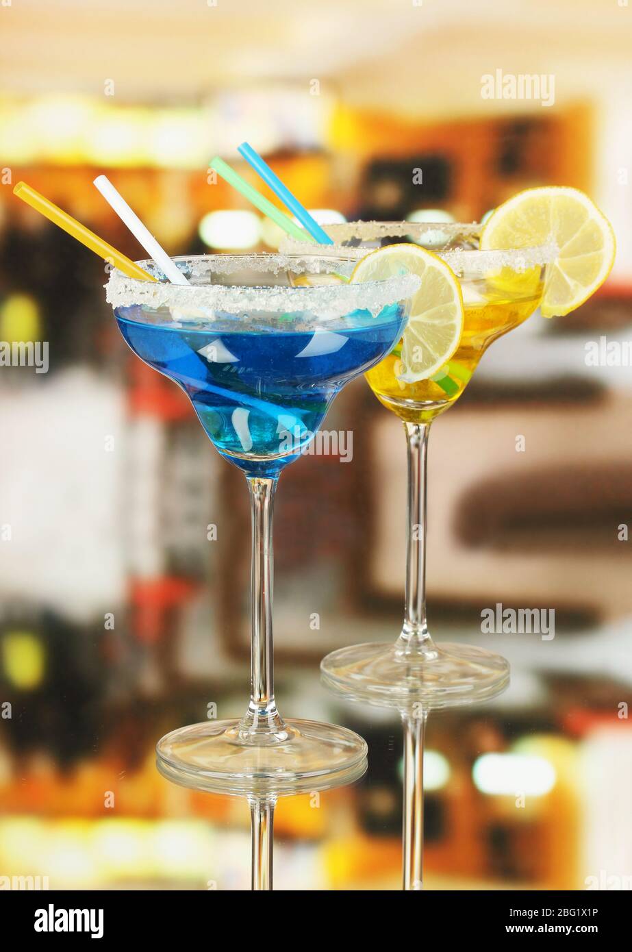 Yellow and blue cocktails in glasses on room background Stock Photo - Alamy