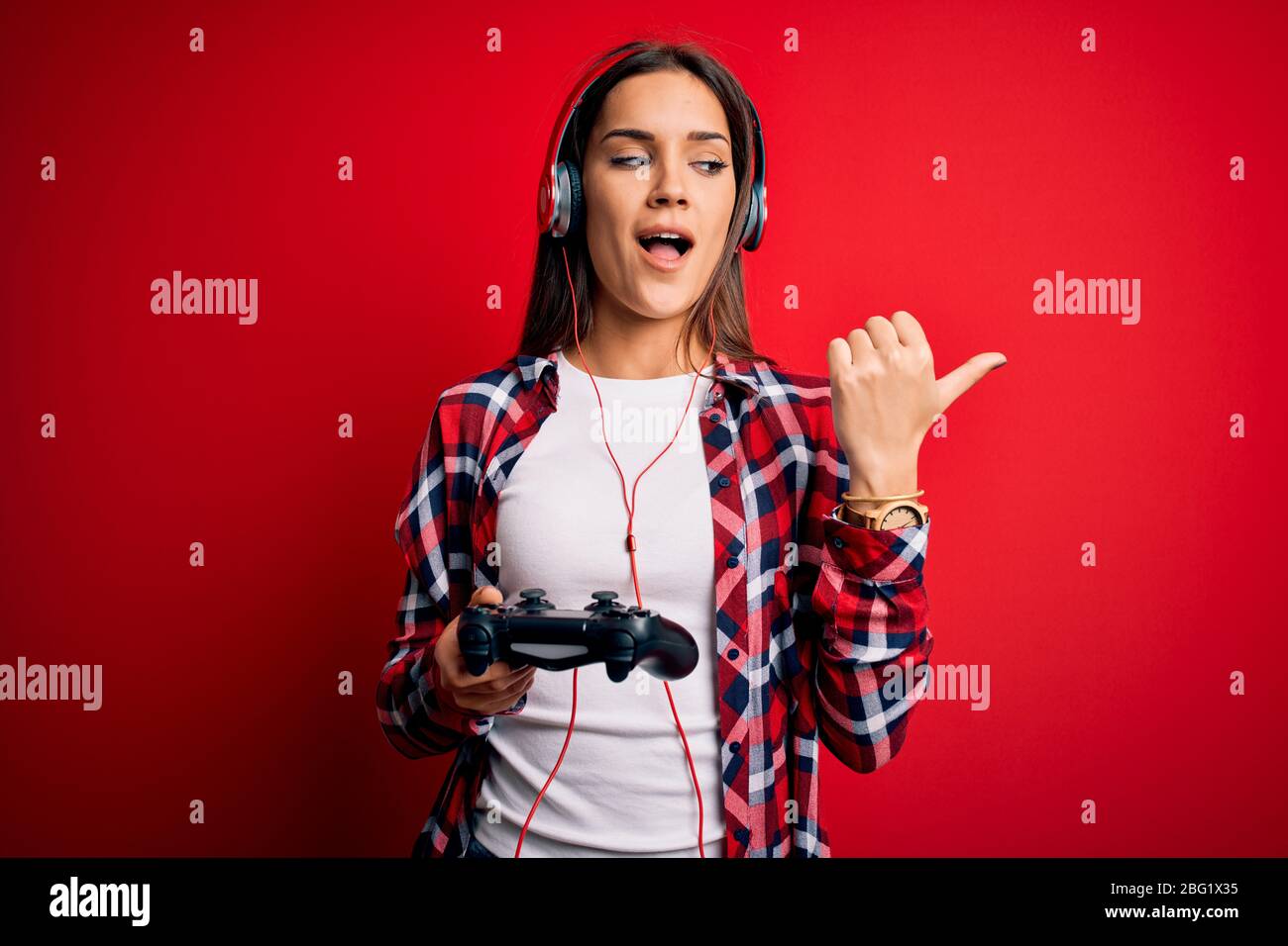 Young beautiful brunette gamer woman playing video game using joystick ...