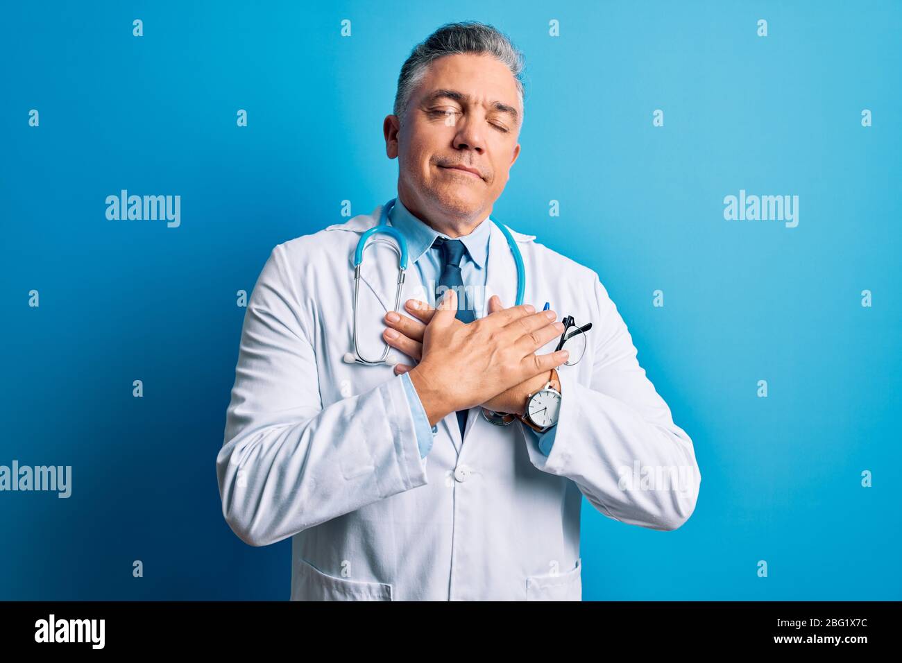 Middle age handsome grey-haired doctor man wearing coat and blue ...
