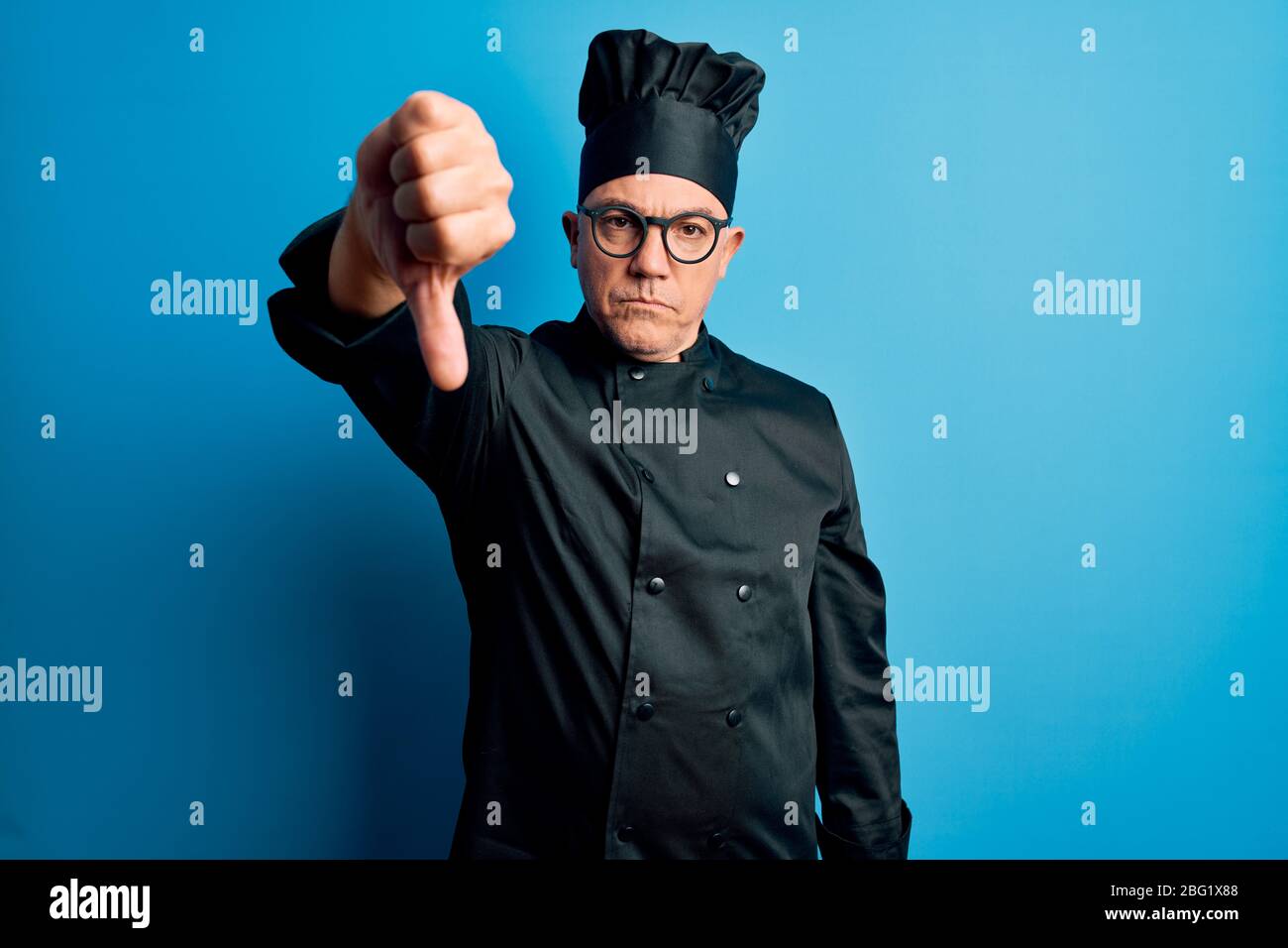 Middle age handsome grey-haired chef man wearing cooker uniform and hat ...