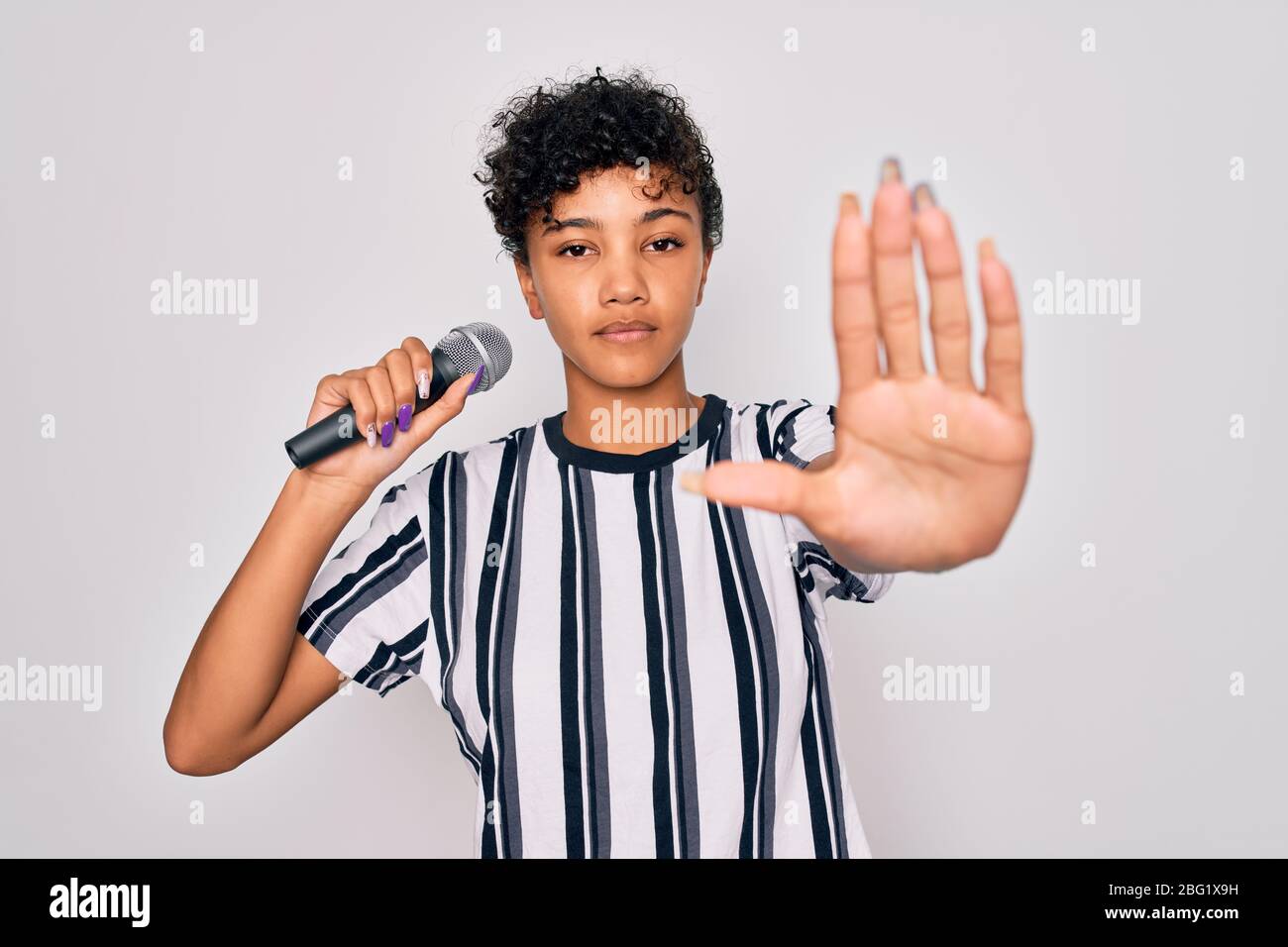 Beautiful african american afro singer woman singing using microphone ...