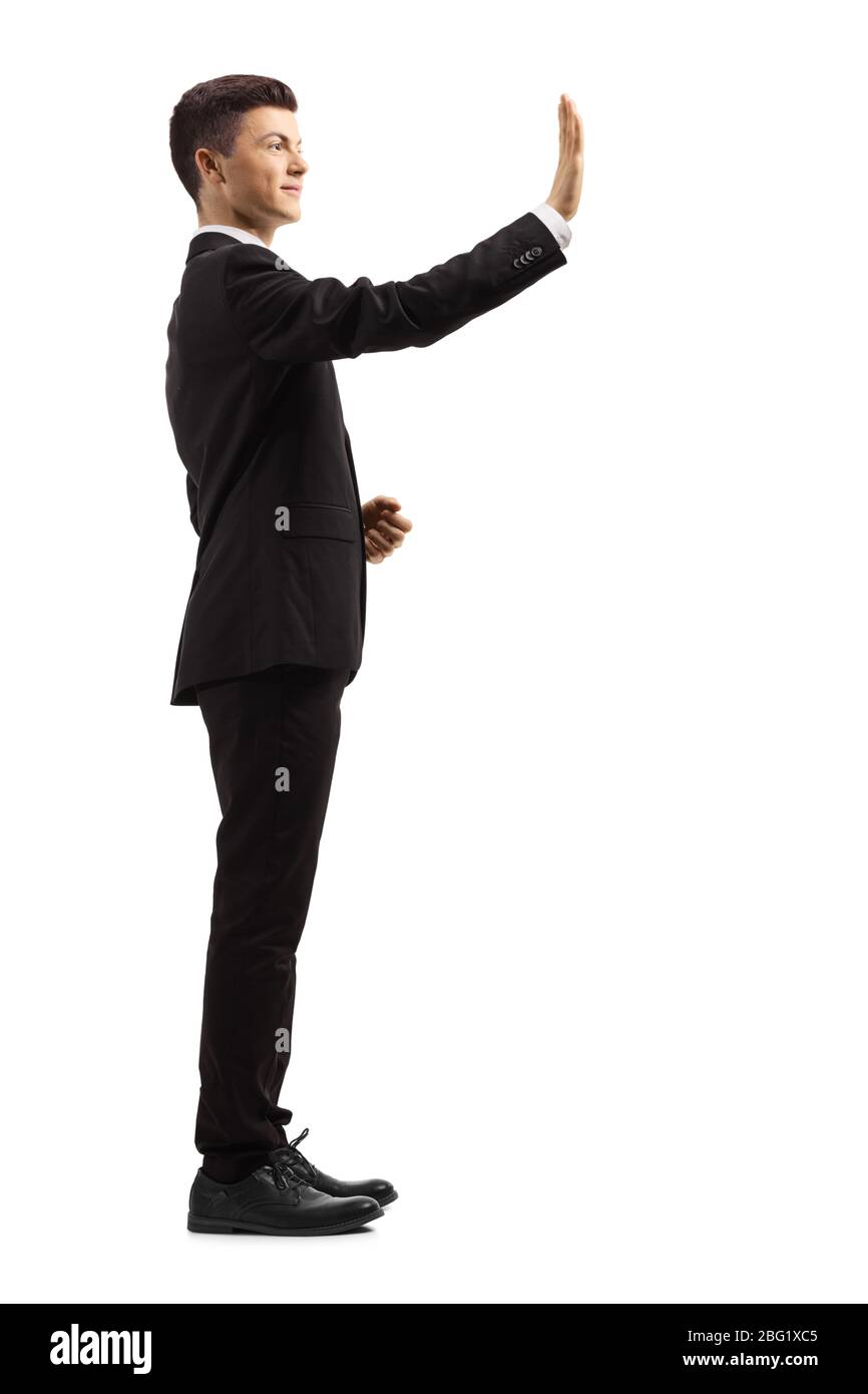 Full length profile shot of young man in a suit greeting with hand ...