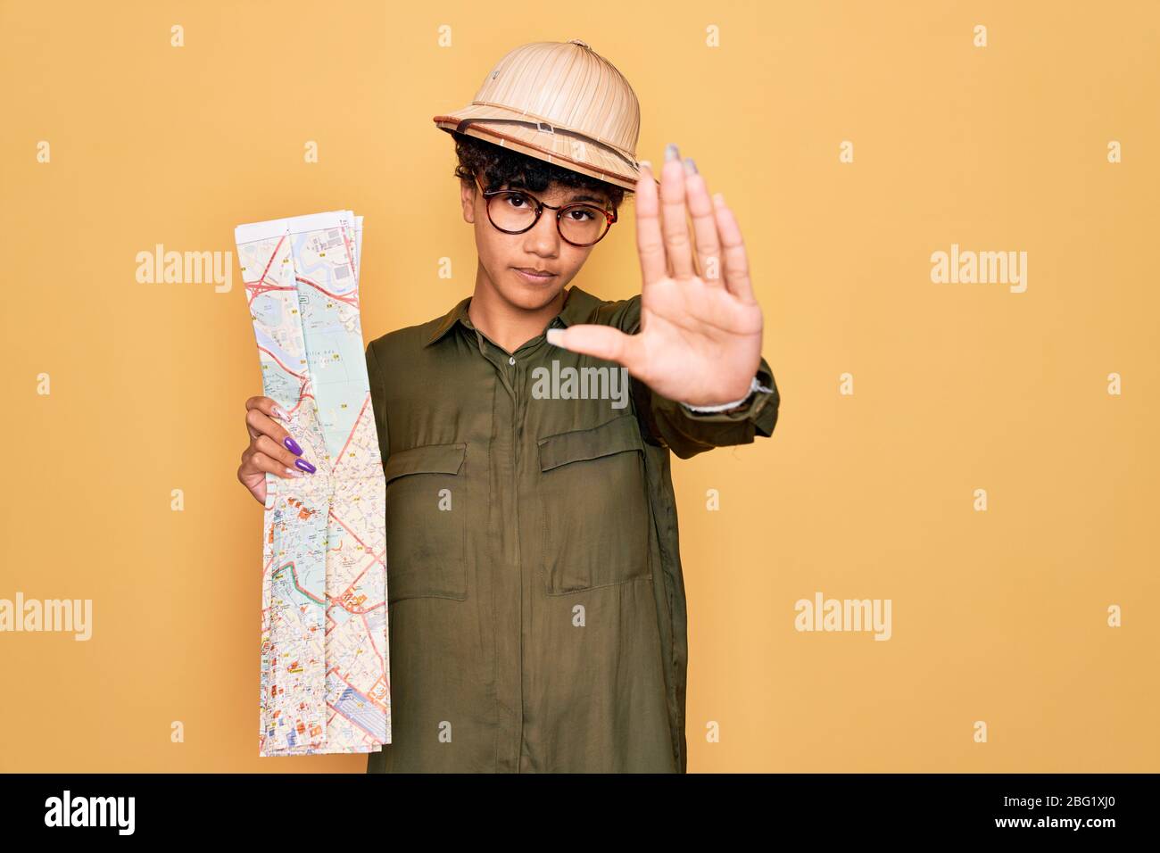 Beautiful african american explorer woman wearing hat holding city map ...