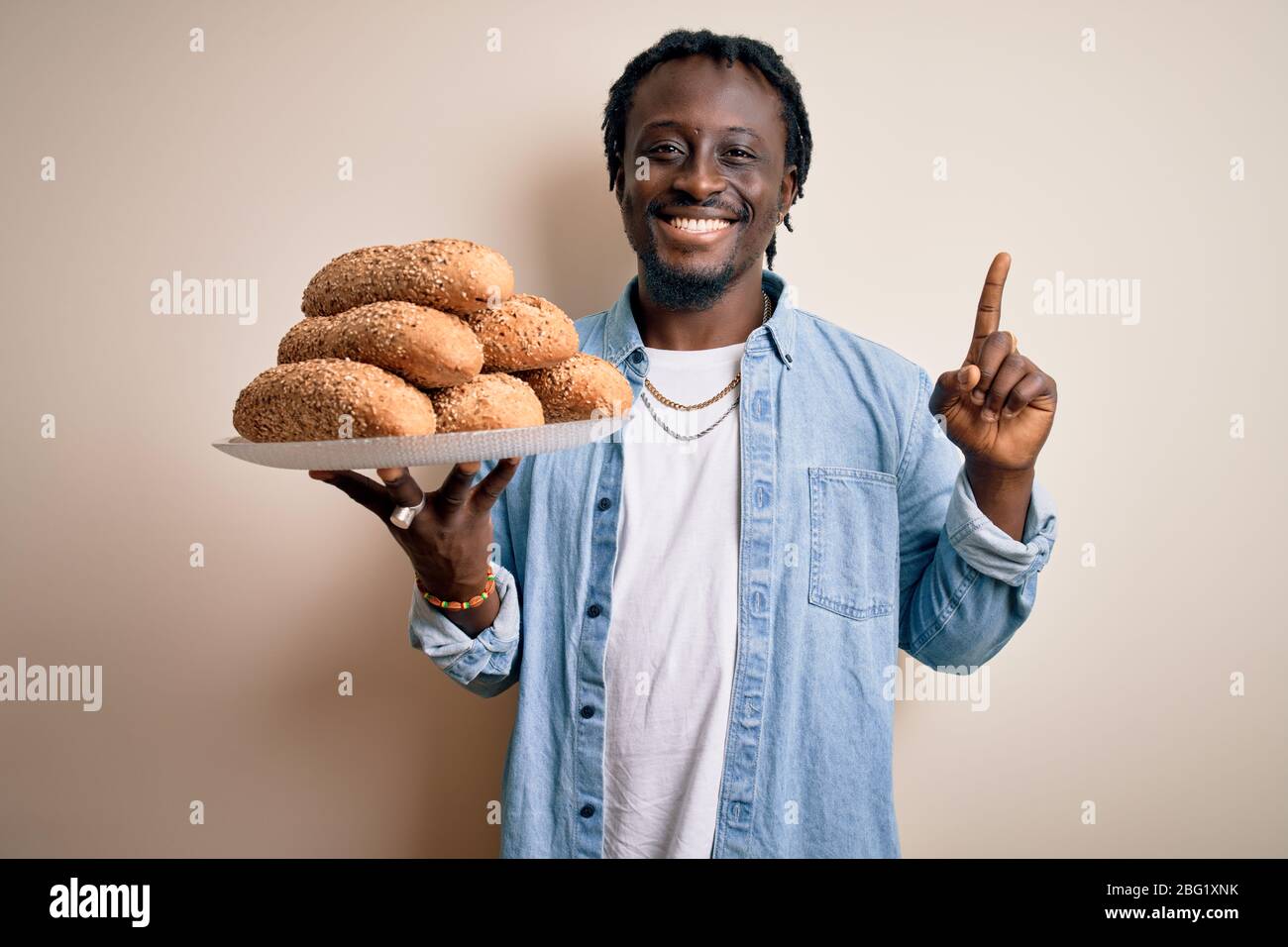 Young african american man holding tray with healthy wholemeal bread ...