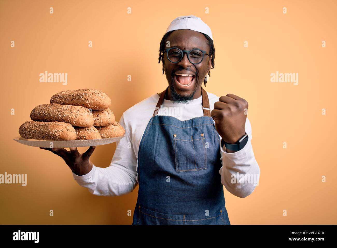 Young african american bakery man holding tray with healthy wholemeal ...