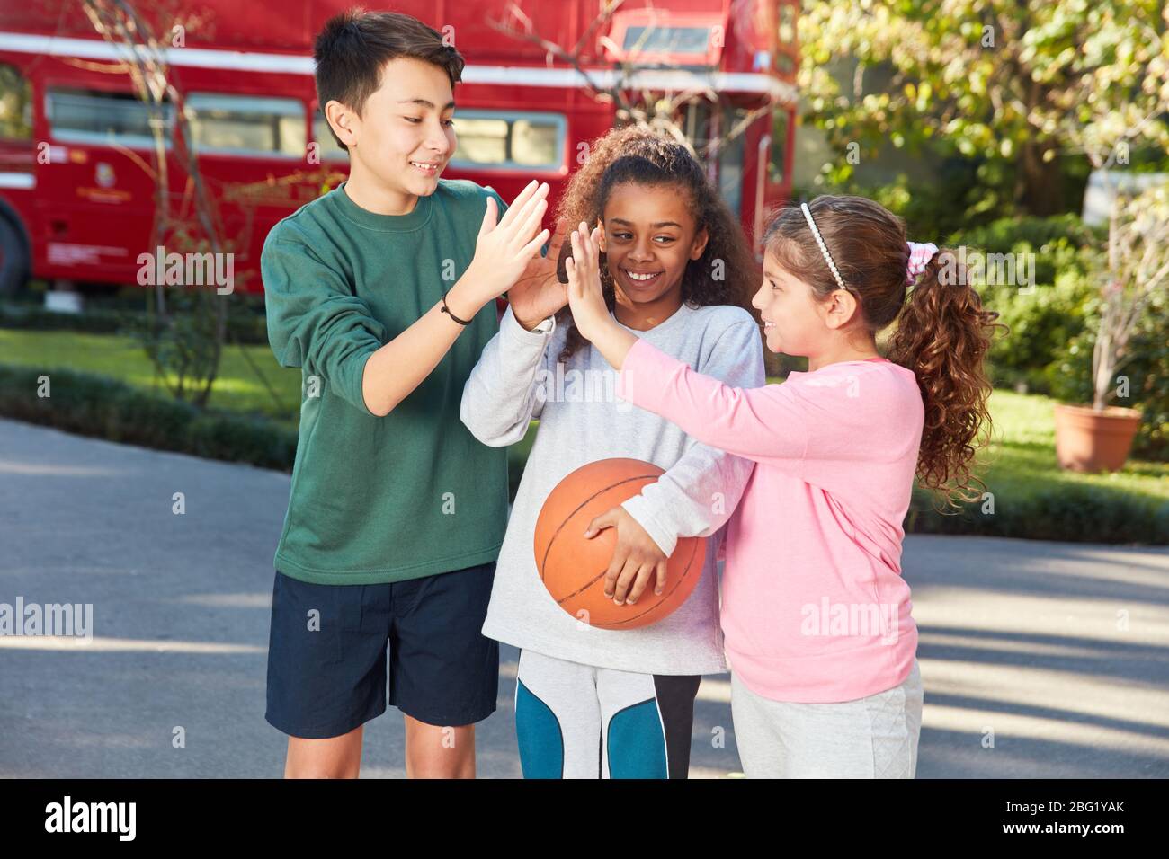 Multicultural students in primary school at sports give High Five ...
