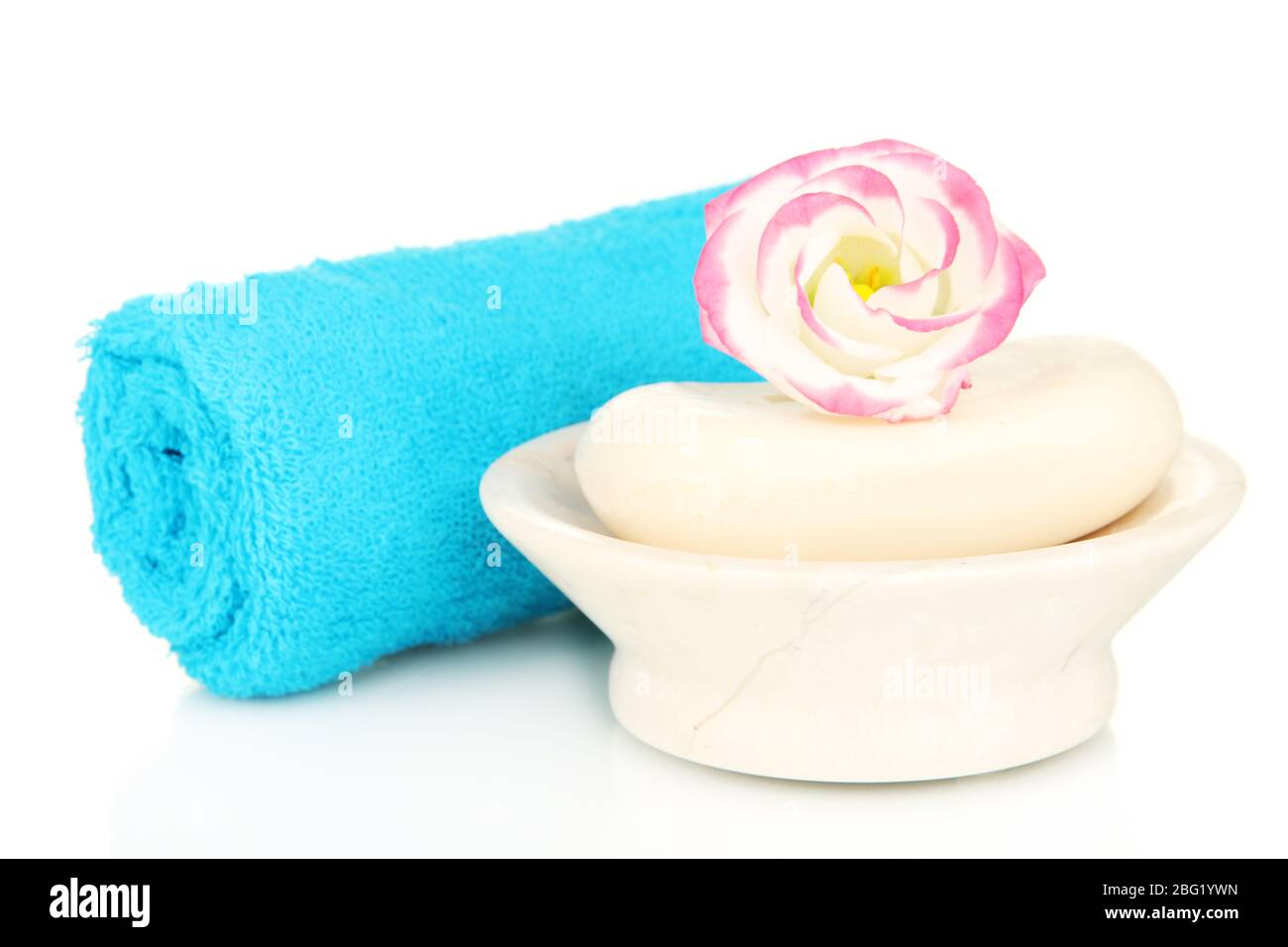Rolled blue towel, soap bar and beautiful flower isolated on white ...