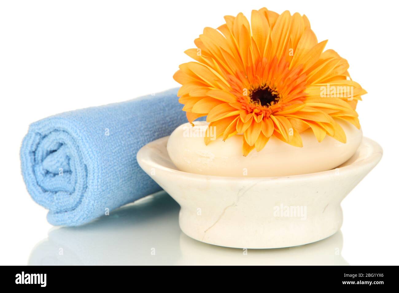 Rolled blue towel, soap bar and beautiful flower isolated on white ...