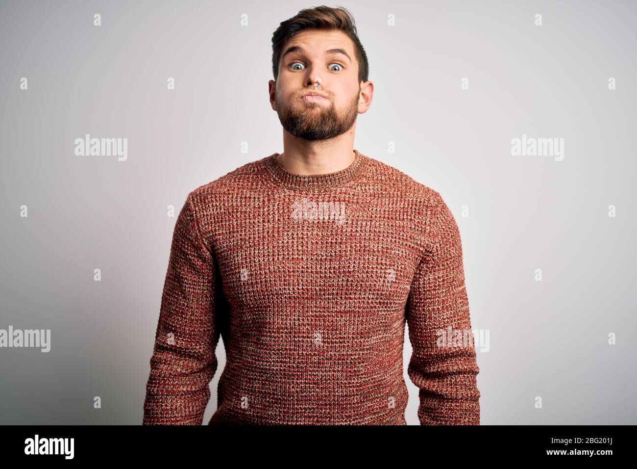 Young blond man with beard and blue eyes wearing casual sweater over ...