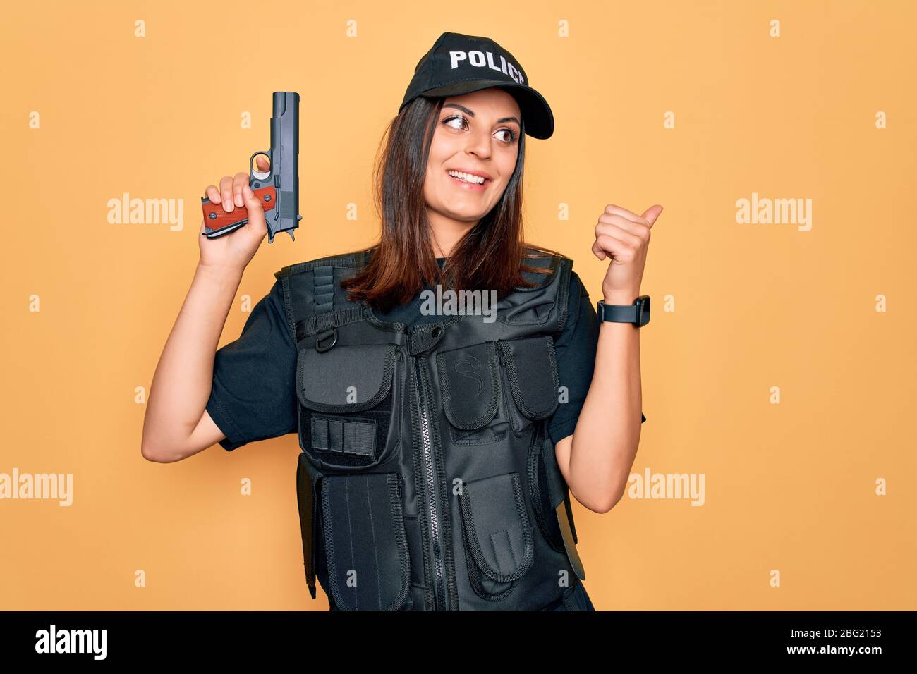 Young beautiful brunette policewoman wearing police uniform bulletproof ...