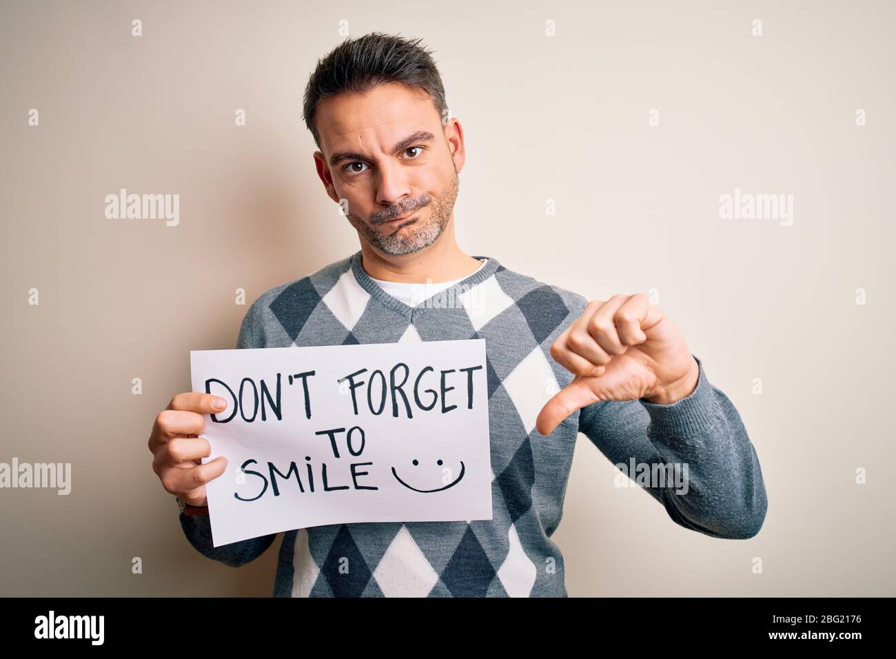 Young handsome man holding banner with funny positive message over ...