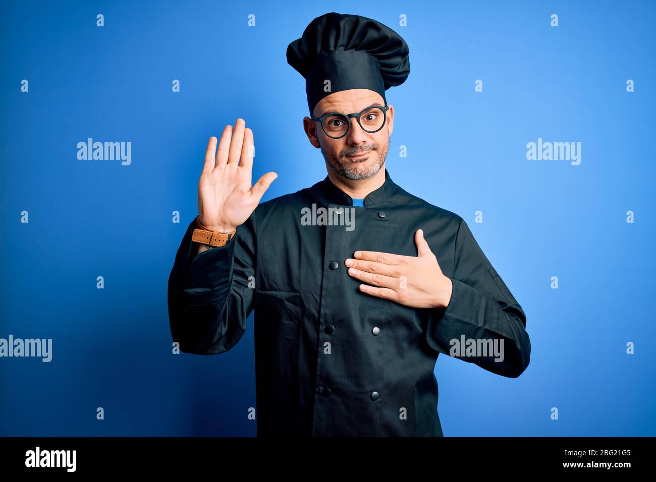 Young handsome chef man wearing cooker uniform and hat over isolated ...