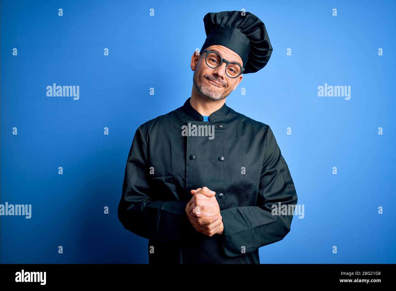 Young handsome chef man wearing cooker uniform and hat over isolated ...