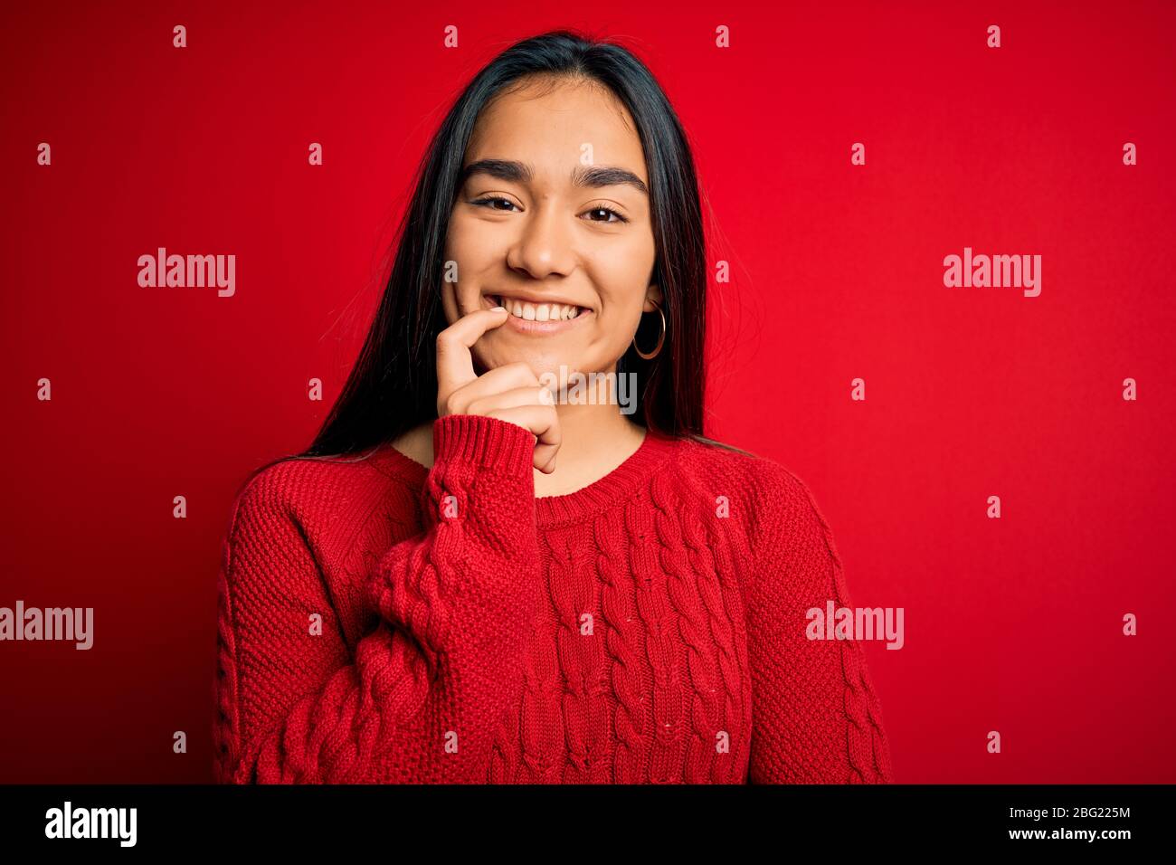 Young beautiful asian woman wearing casual sweater standing over ...