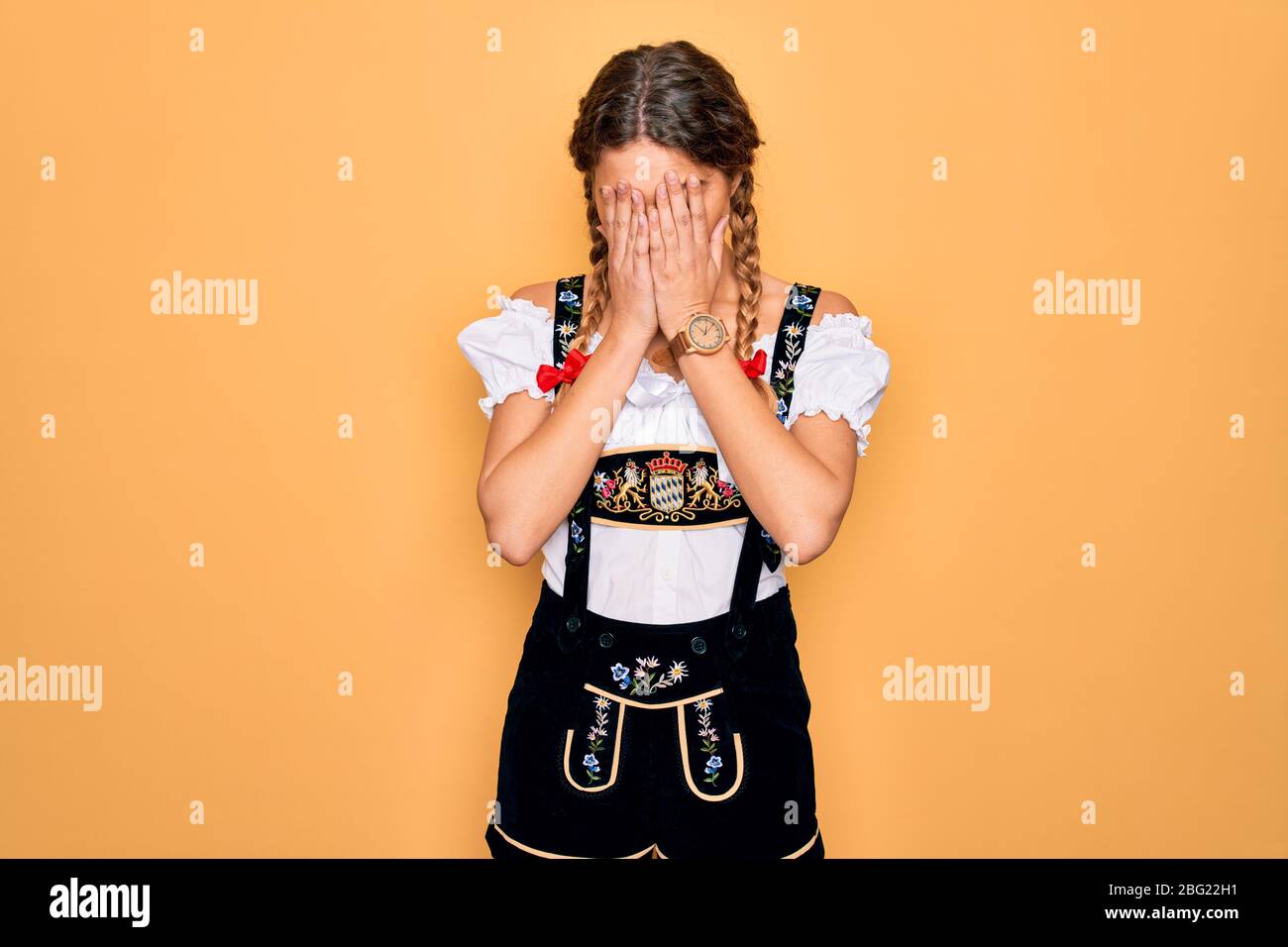 Young beautiful blonde german woman with blue eyes wearing traditional ...