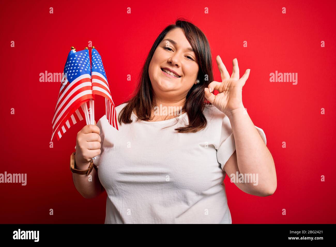 Beautiful plus size woman holding united states of america flag over ...
