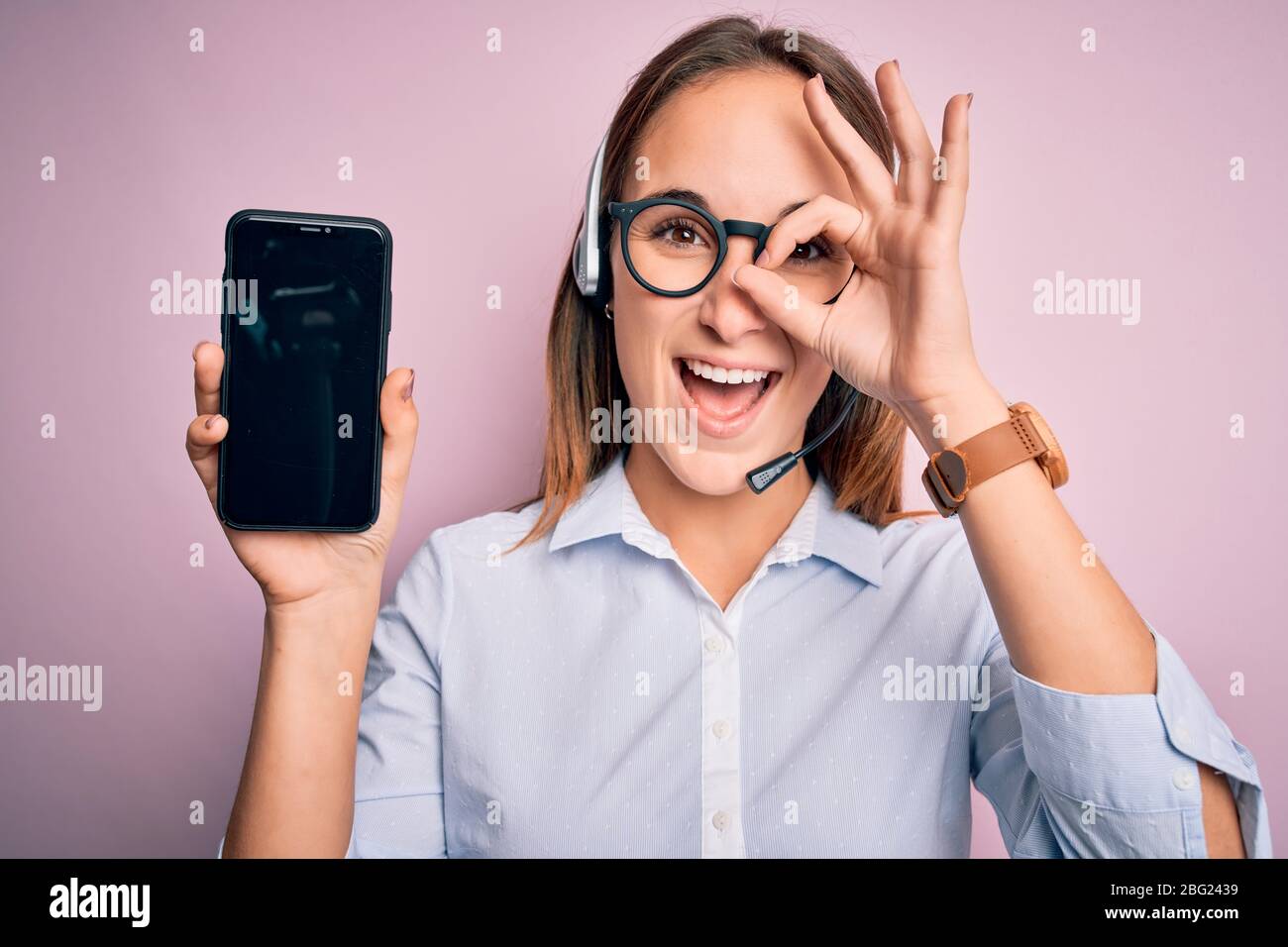 Beautiful call center agent woman working using headset holding ...