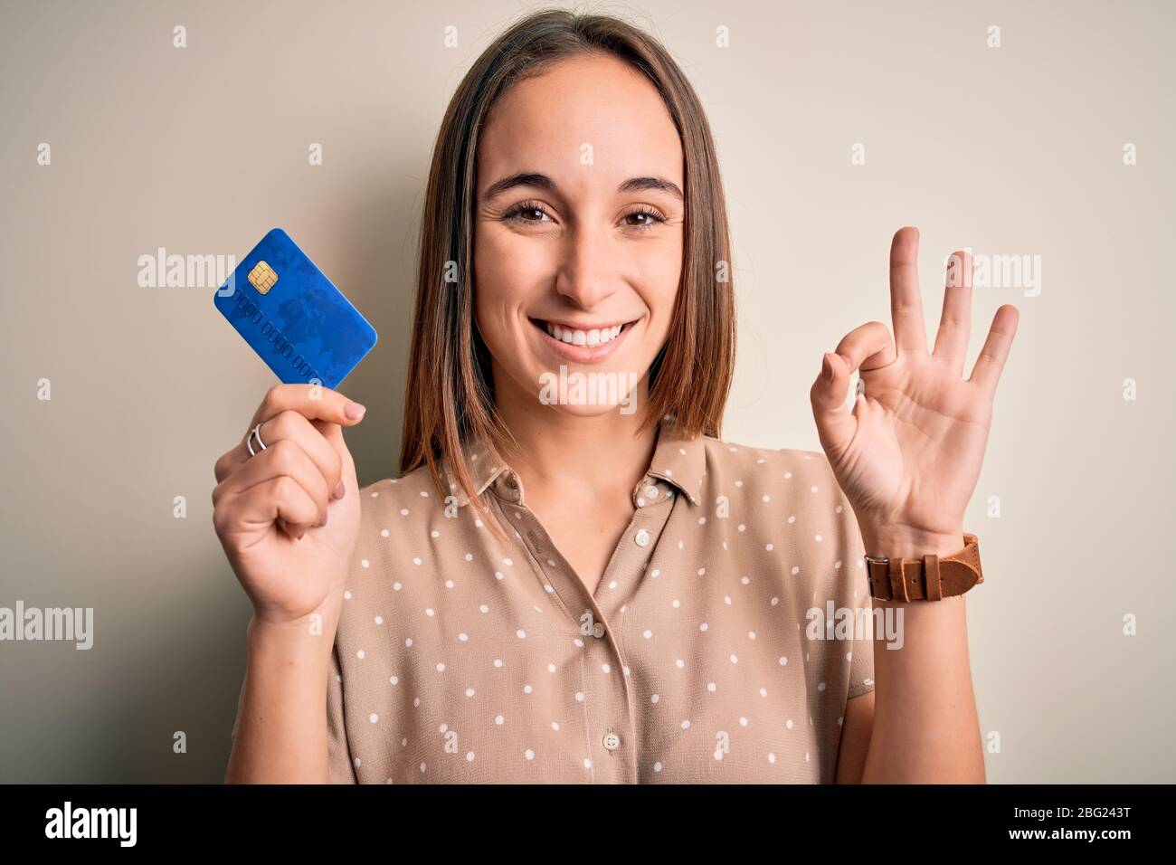 Young beautiful customer woman holding credit card to do payment over ...