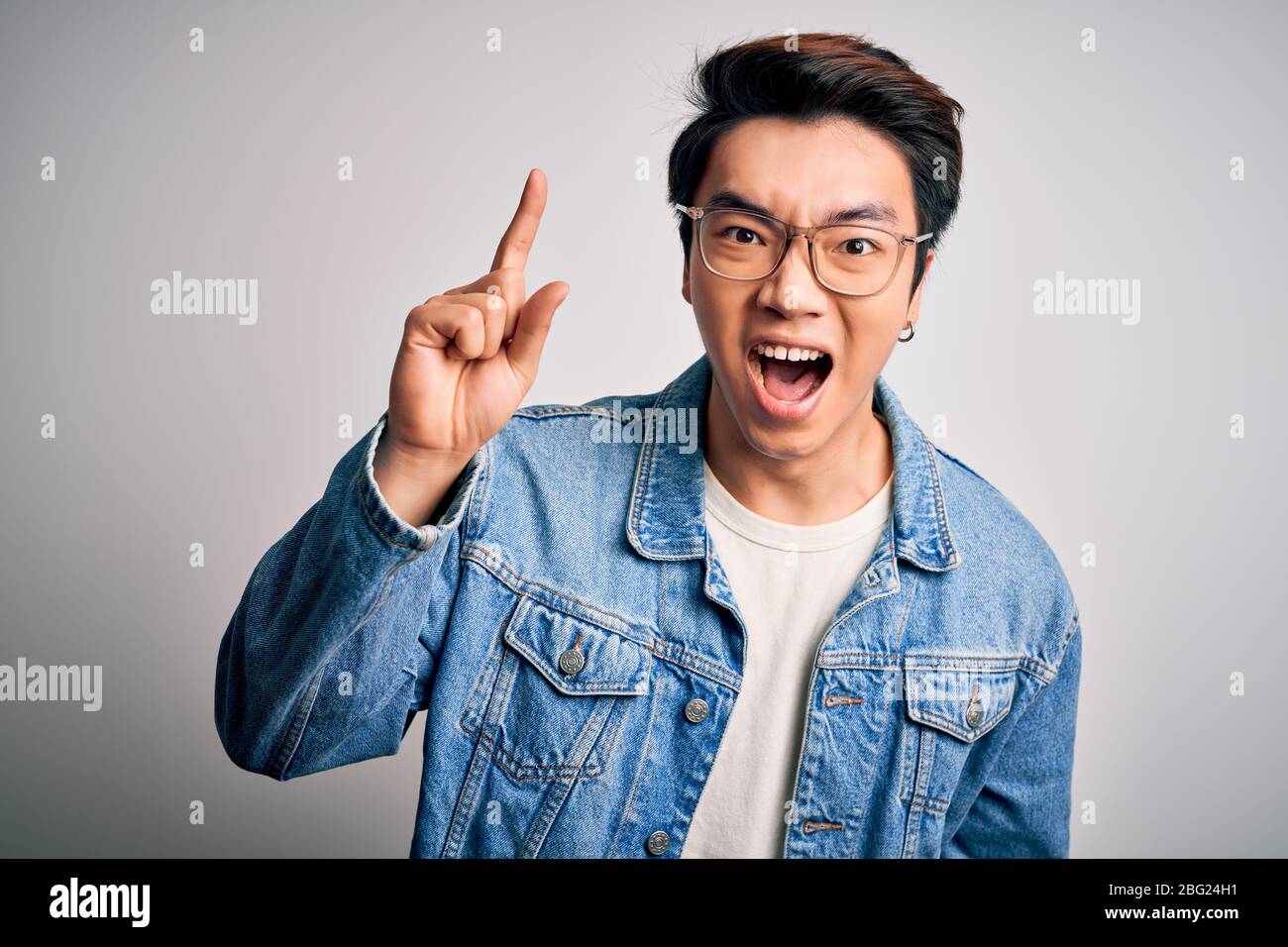 Young handsome chinese man wearing denim jacket and glasses over white ...