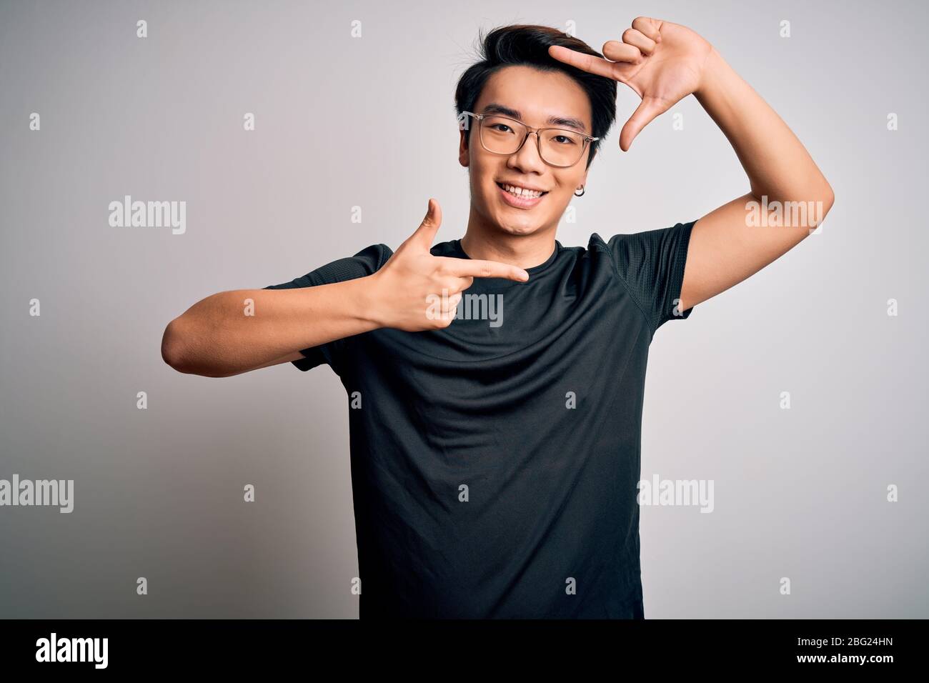 Young handsome chinese man wearing black t-shirt and glasses over white ...
