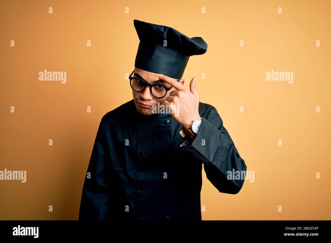 Young brazilian chef man wearing cooker uniform and hat over isolated ...