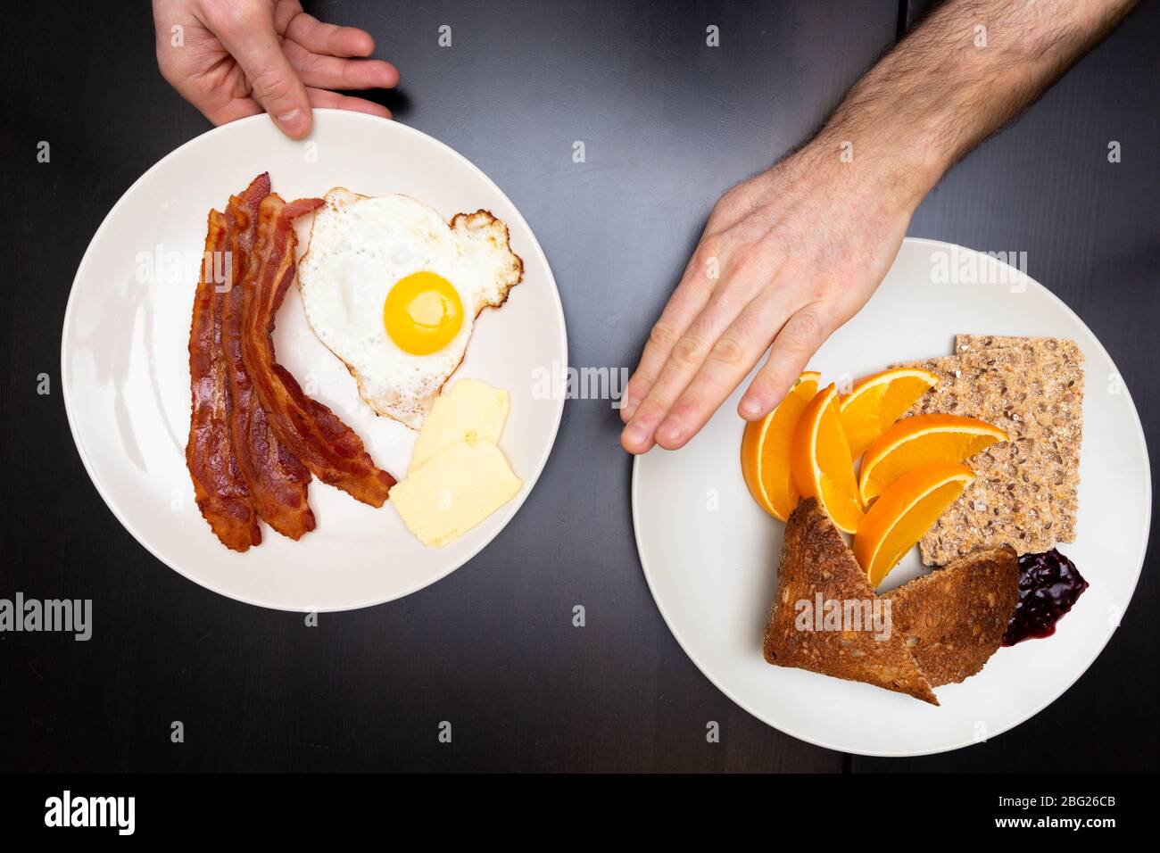 Mans hand pushing away a high carb plate of food in favor of a high fat ...
