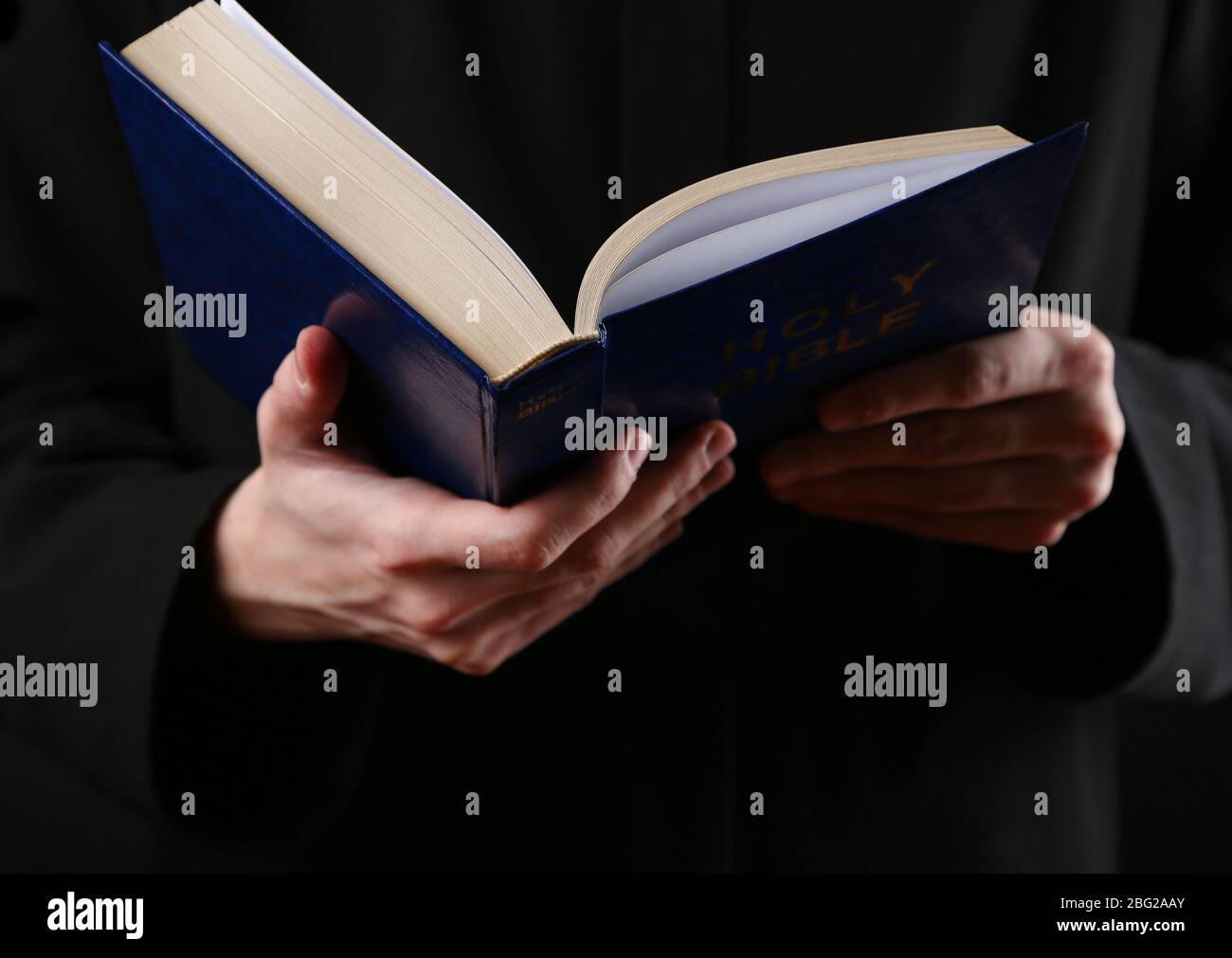 Priest reading from the holy bible, close up Stock Photo - Alamy