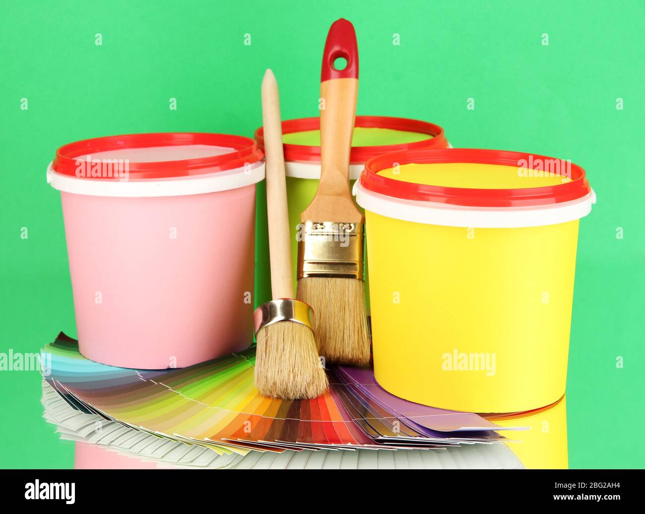 Set for painting: paint pots, brushes, palette of colors on green ...