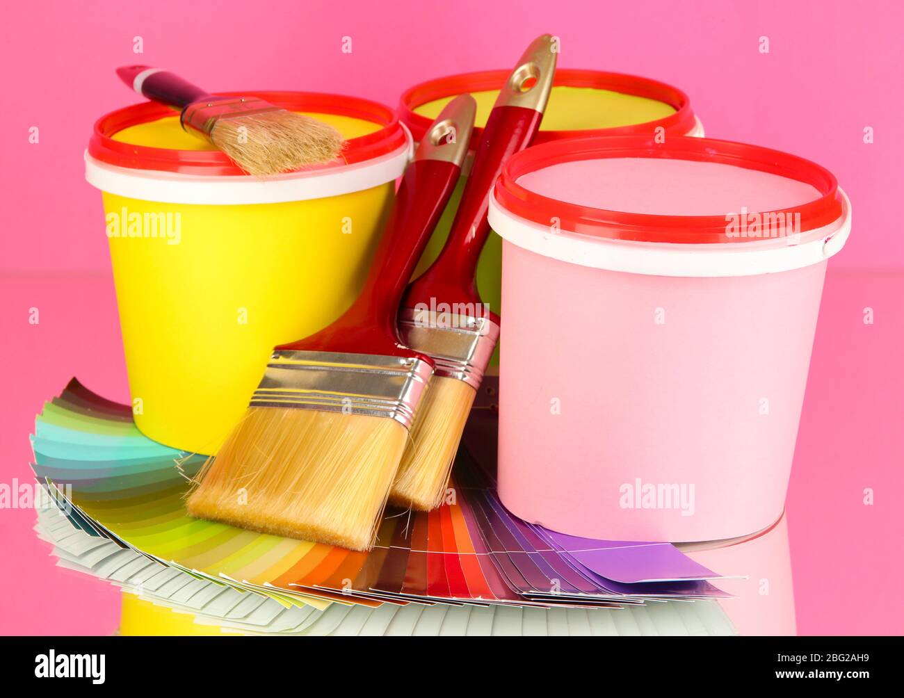 Set for painting: paint pots, brushes, palette of colors on pink ...