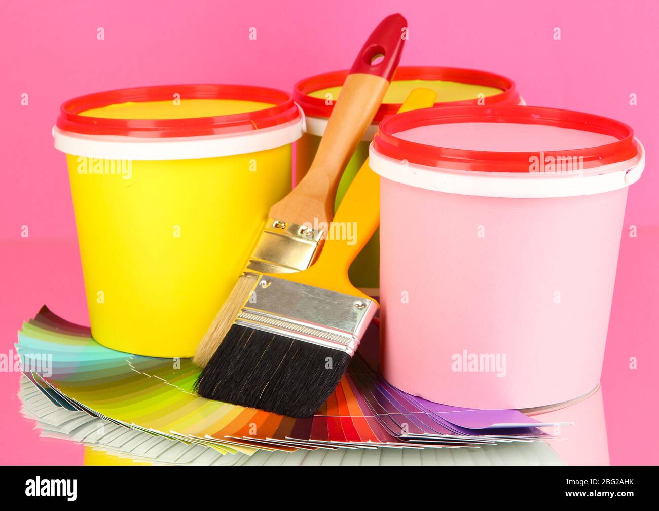 Set for painting: paint pots, brushes, palette of colors on pink ...