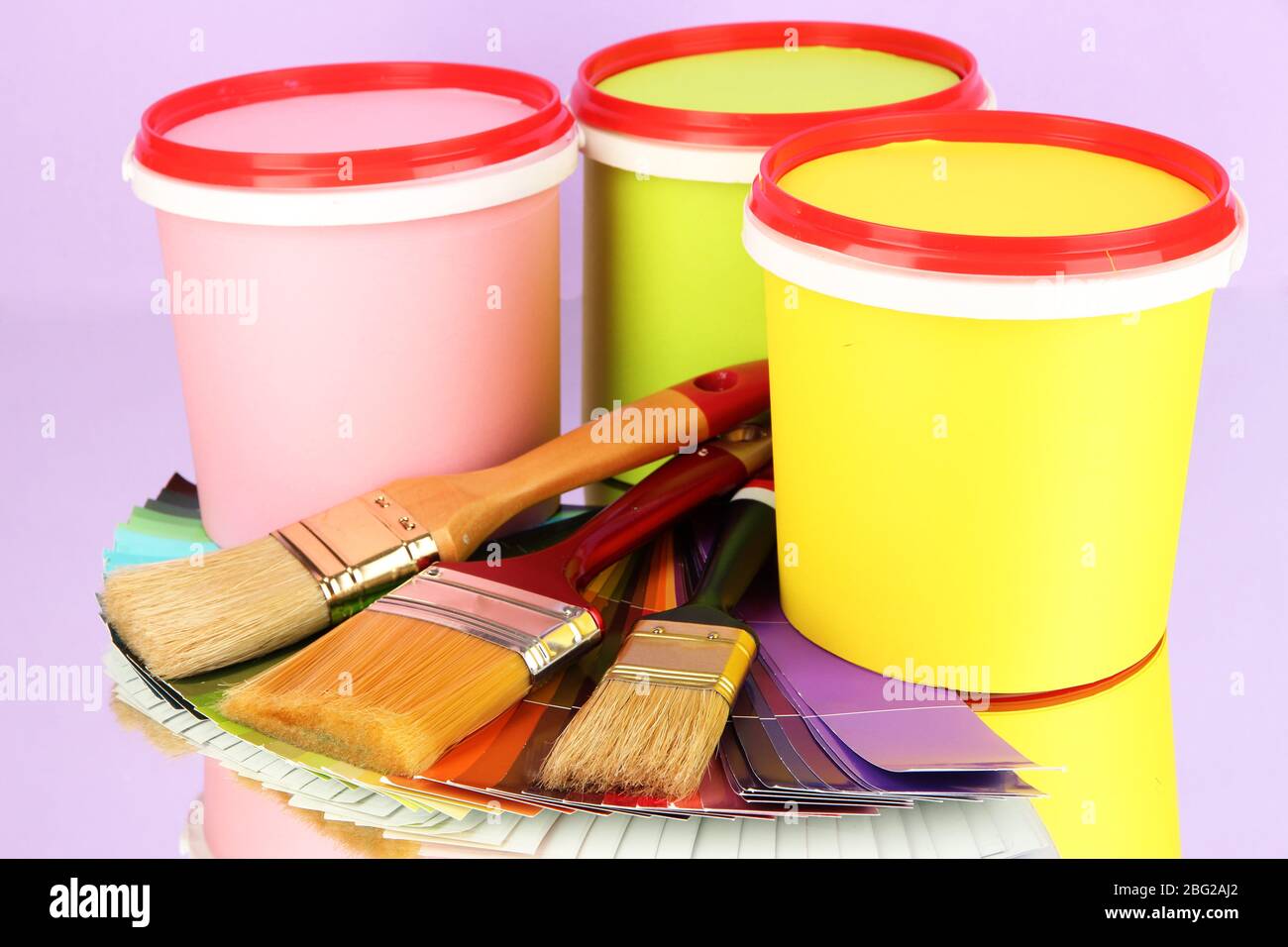 Set for painting: paint pots, brushes, palette of colors on lilac ...