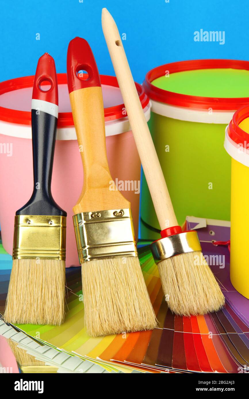 Set for painting: paint pots, brushes, palette of colors on blue ...