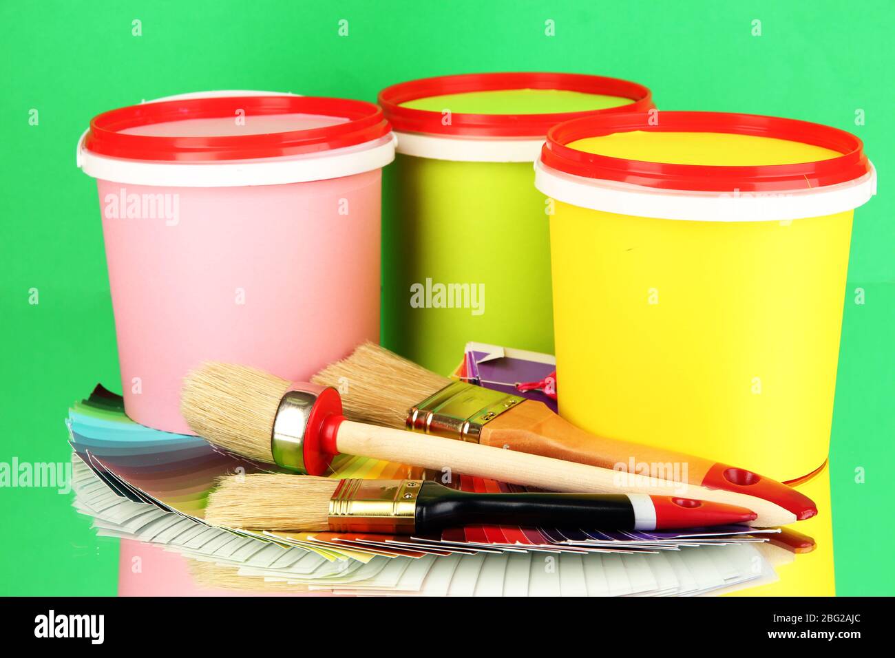 Set for painting: paint pots, brushes, palette of colors on green ...