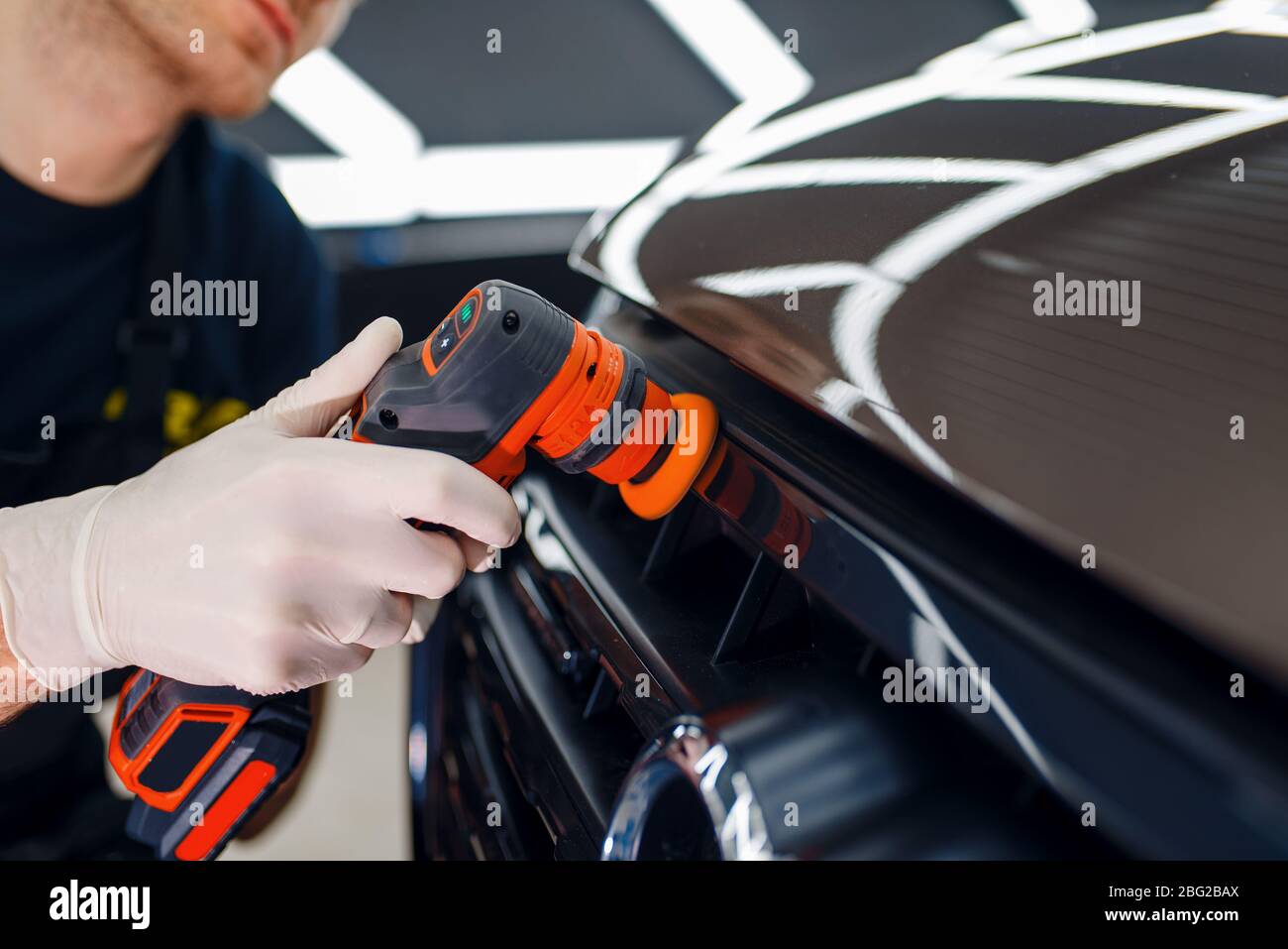 Worker polishes radiator grille, car detailing Stock Photo - Alamy