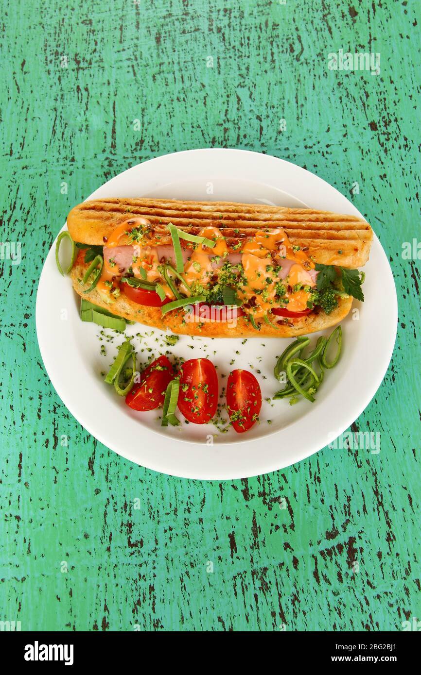 Delicious hot dog on plate on wooden table close-up Stock Photo - Alamy