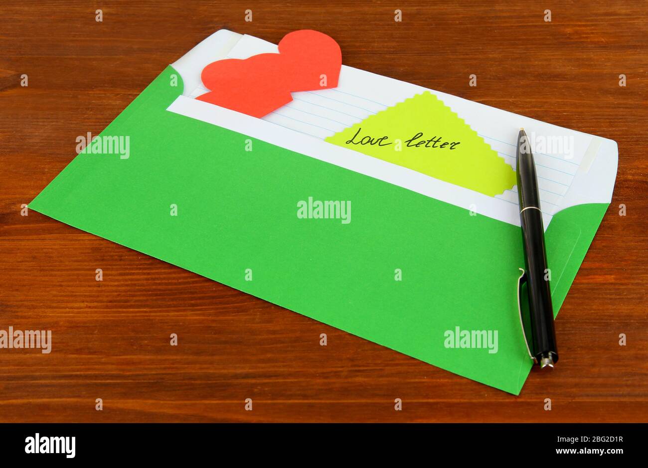 Note in envelope with pen on wooden background Stock Photo - Alamy