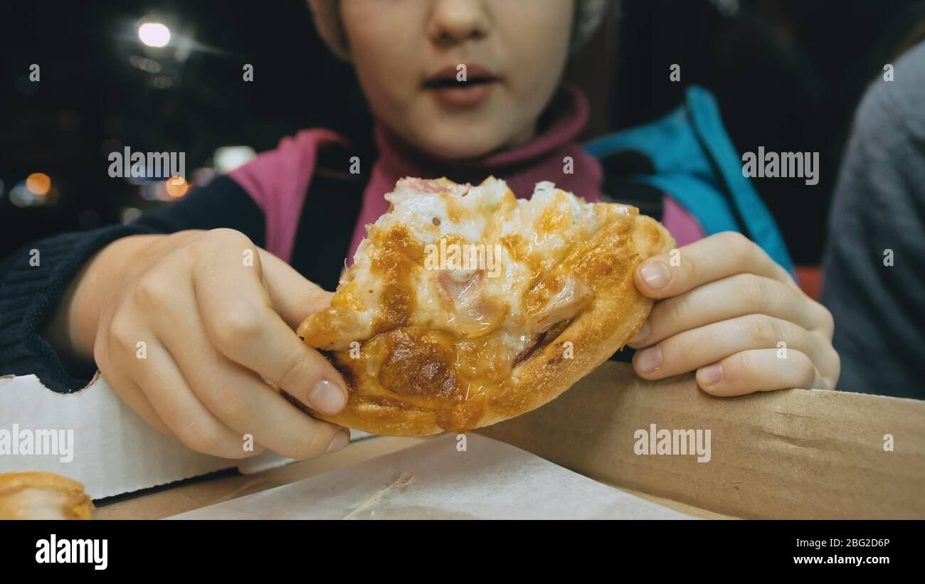 Child eat pizza cheese four. Close up of young girl woman eating pizza ...