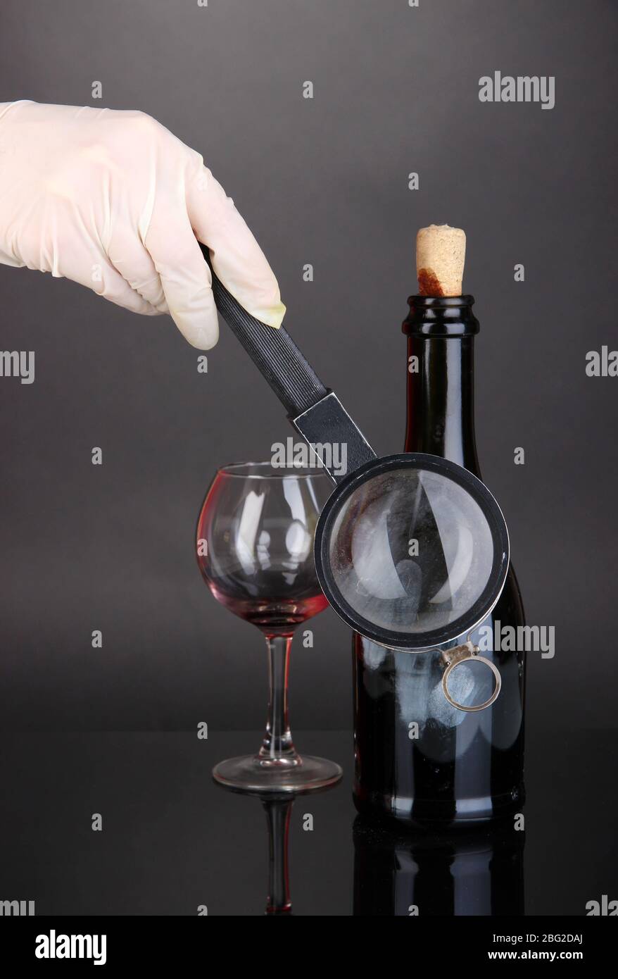 Taking fingerprints with bottle of wine isolated on black Stock Photo ...