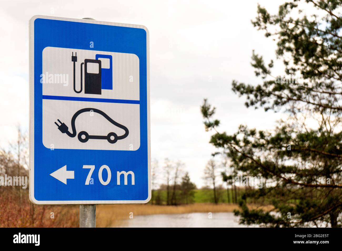 Electric car charging point sign in nature. EV parking and recharging ...