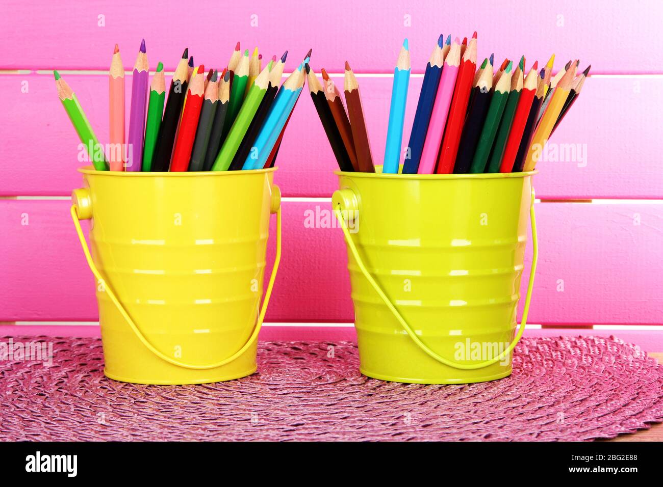 Colorful pencils in two pails on table on pink background Stock Photo ...