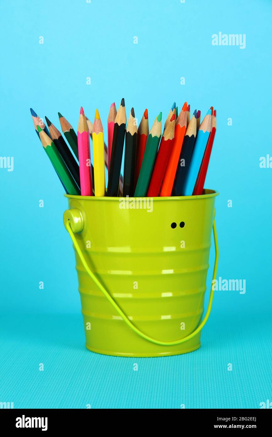 Colorful pencils in pail on blue background Stock Photo - Alamy