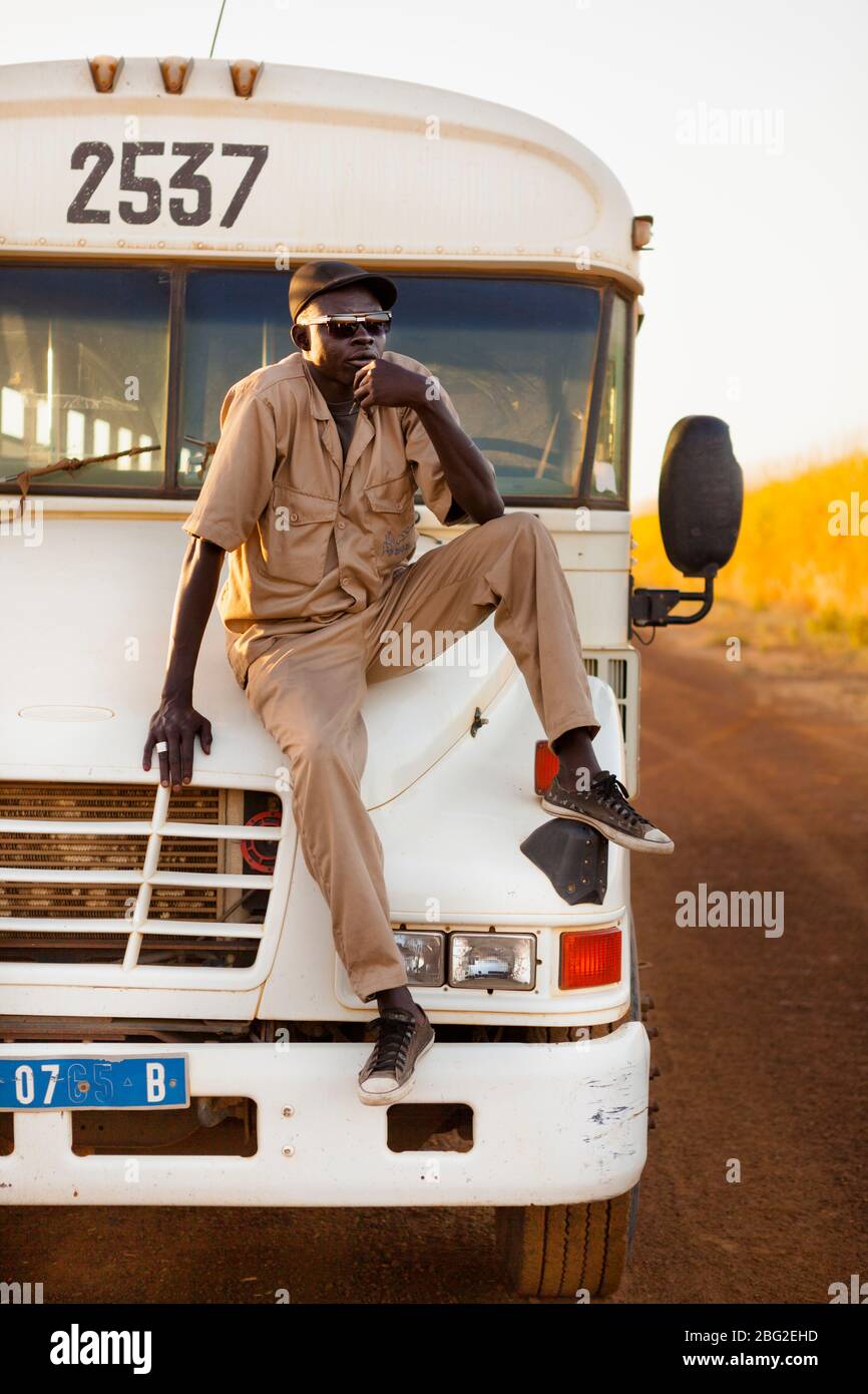 Bus driver chilling on the hood at sunset, Senegal Stock Photo - Alamy